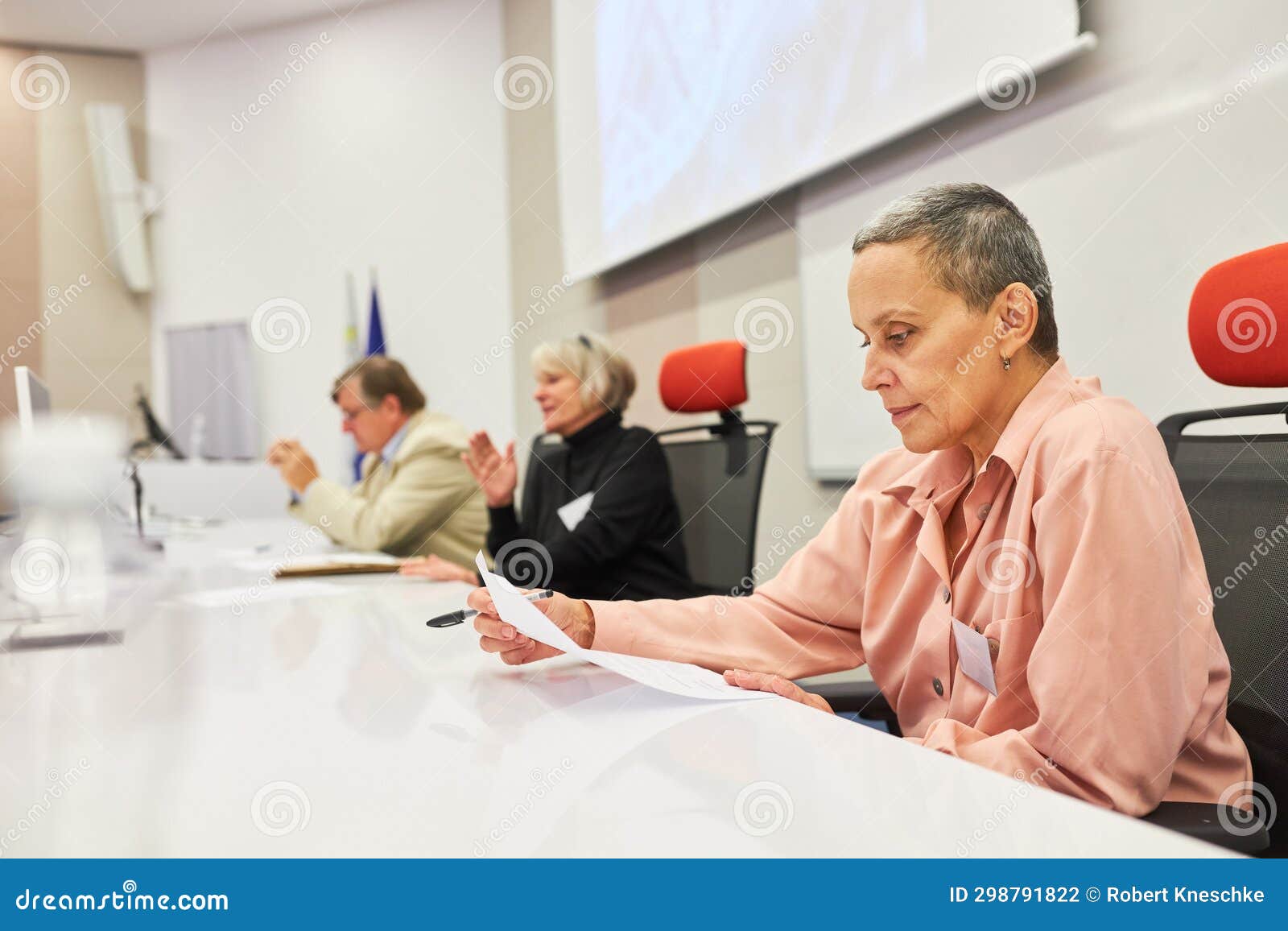 Speaker Reading Document at Table in Convention Center Stock Photo ...