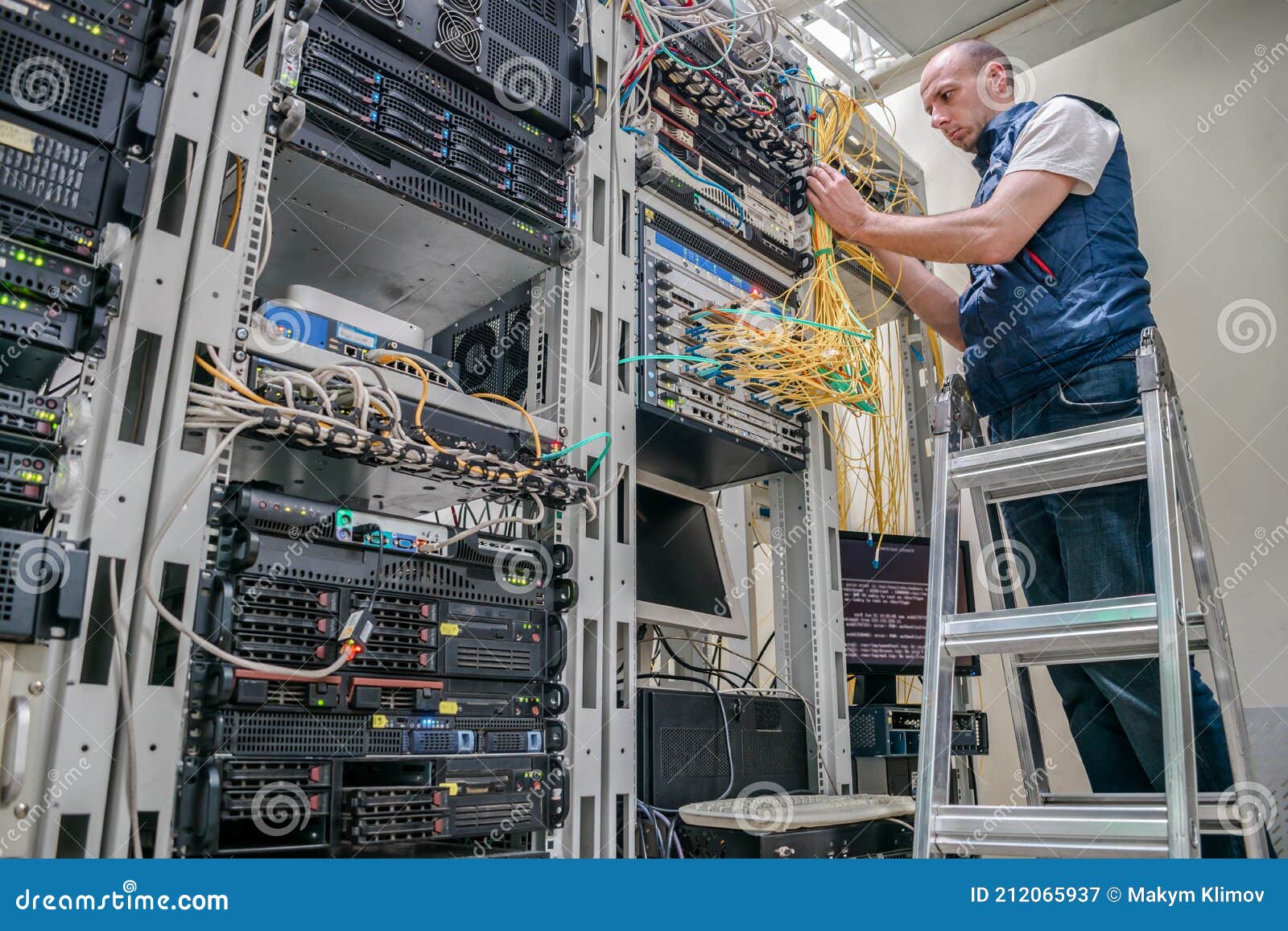 The Specialist Works in the Server Room of the Data Center. Worker Lays ...