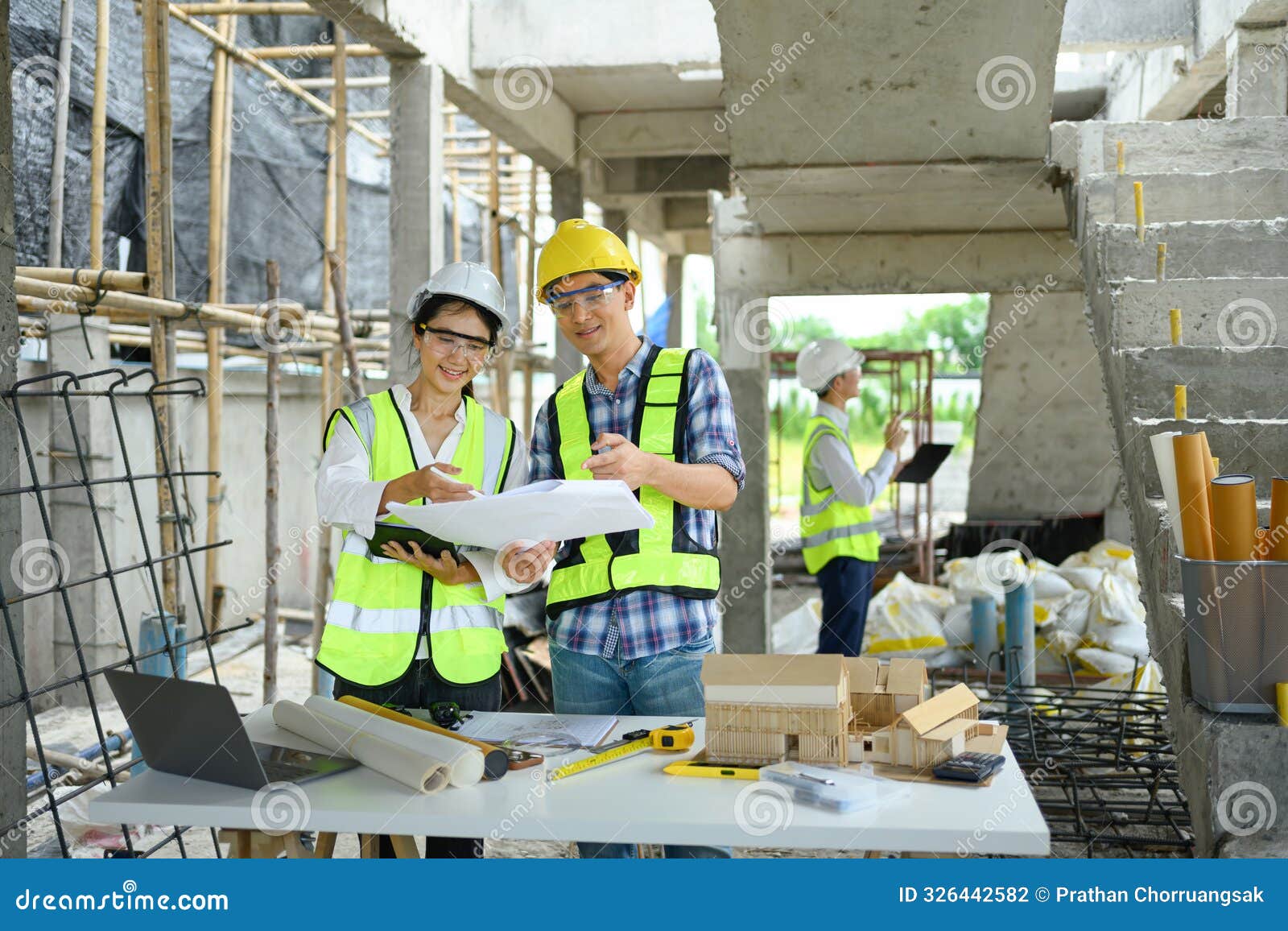Specialists Team in Safety Vest and Helmet Discussing Structure of the ...
