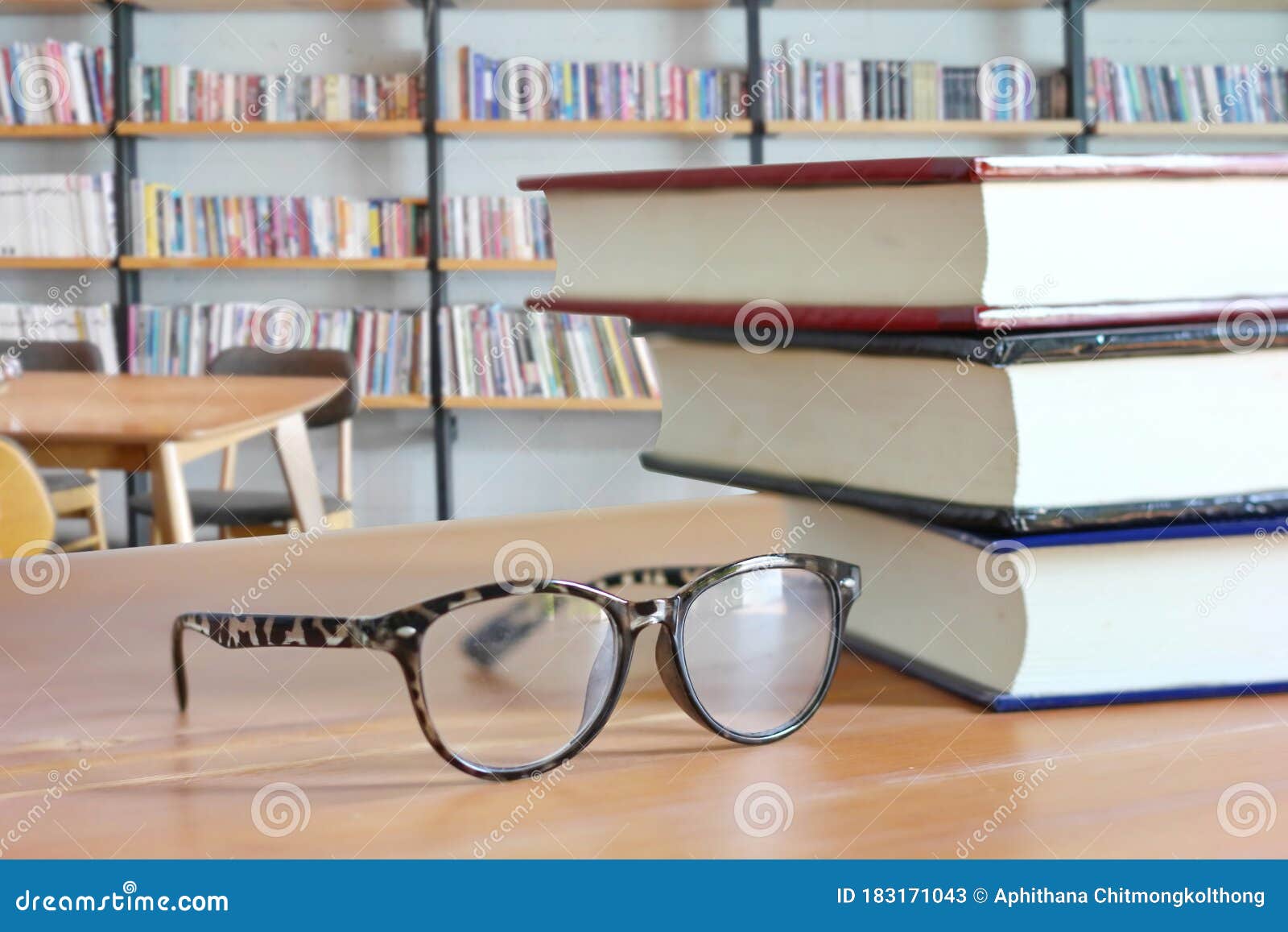 The Spectacles with Book on Wood Table with Bookshelf Background Stock ...