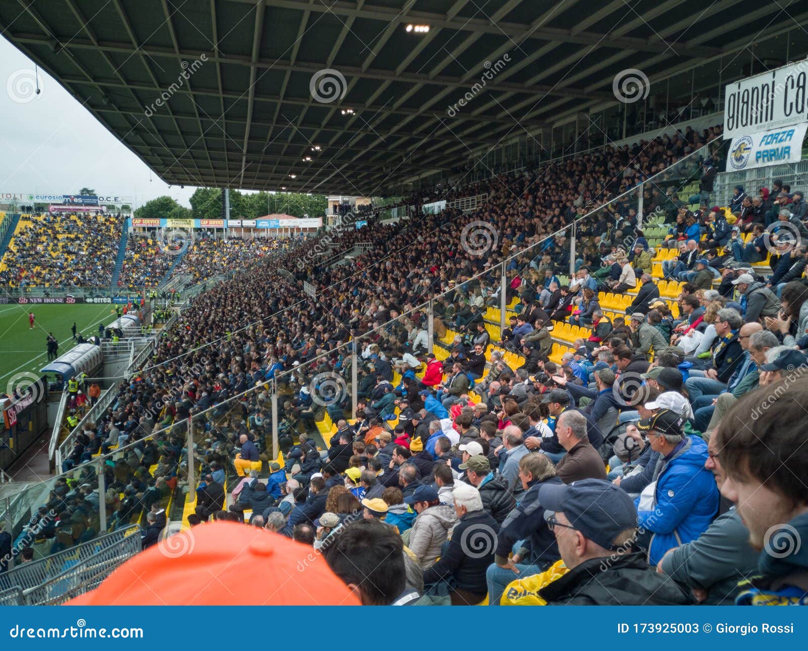 Spectators during a Soccer Match Sitting at the Covered Stand of the ...