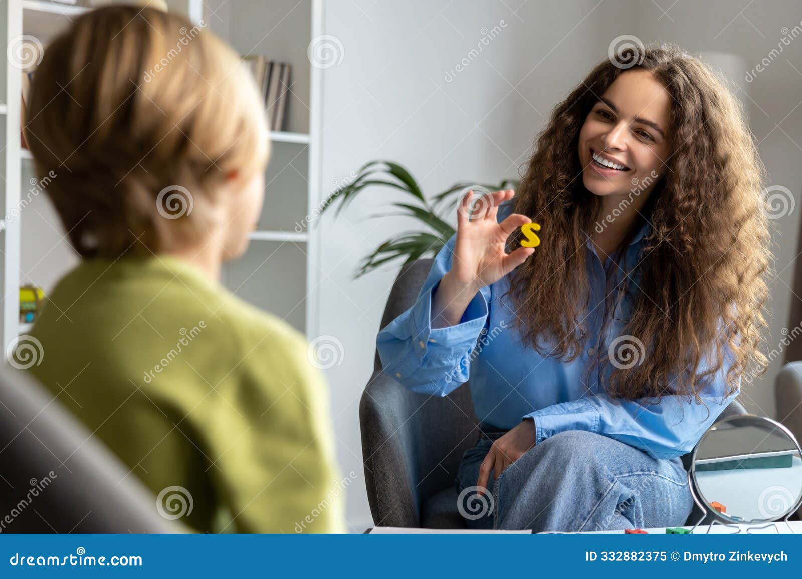 Long-haired Young Speech Therapist Working with a Blonde Boy and Both ...