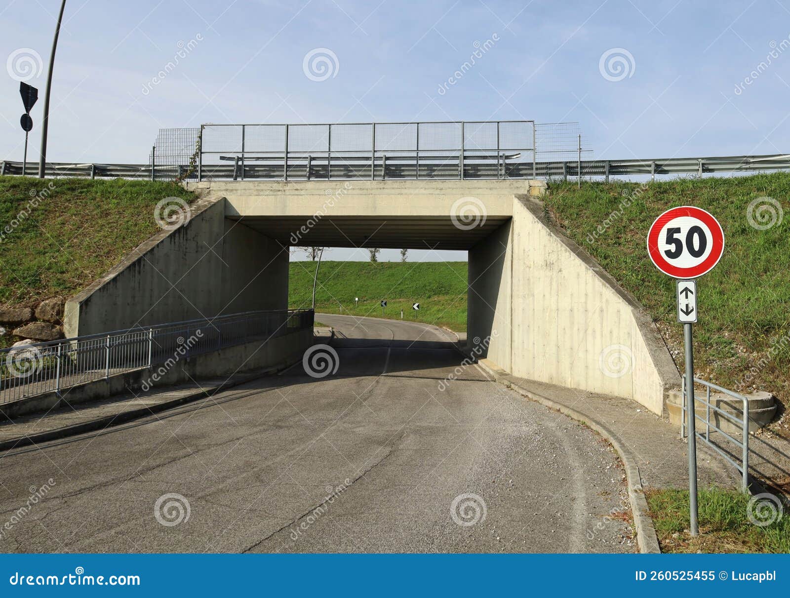 Speed Limit Sign in Front of a Concrete Road Underpass with Sidewalks ...