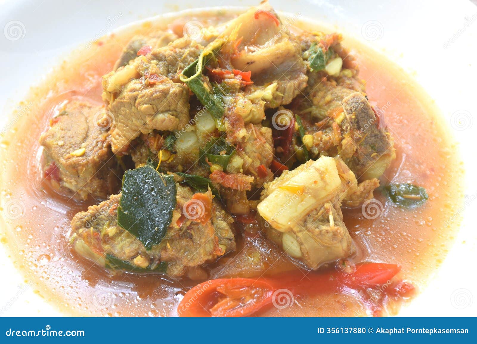 Spicy Fried Pork Soft Bone with Curry and Basil on Plate Stock Photo ...