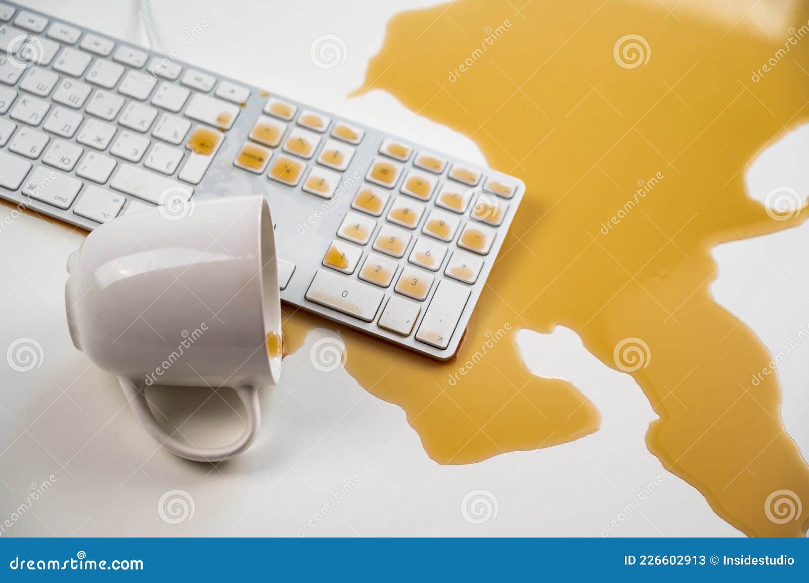 Spilled Cup of Black Coffee on Computer Keyboard on White Table ...