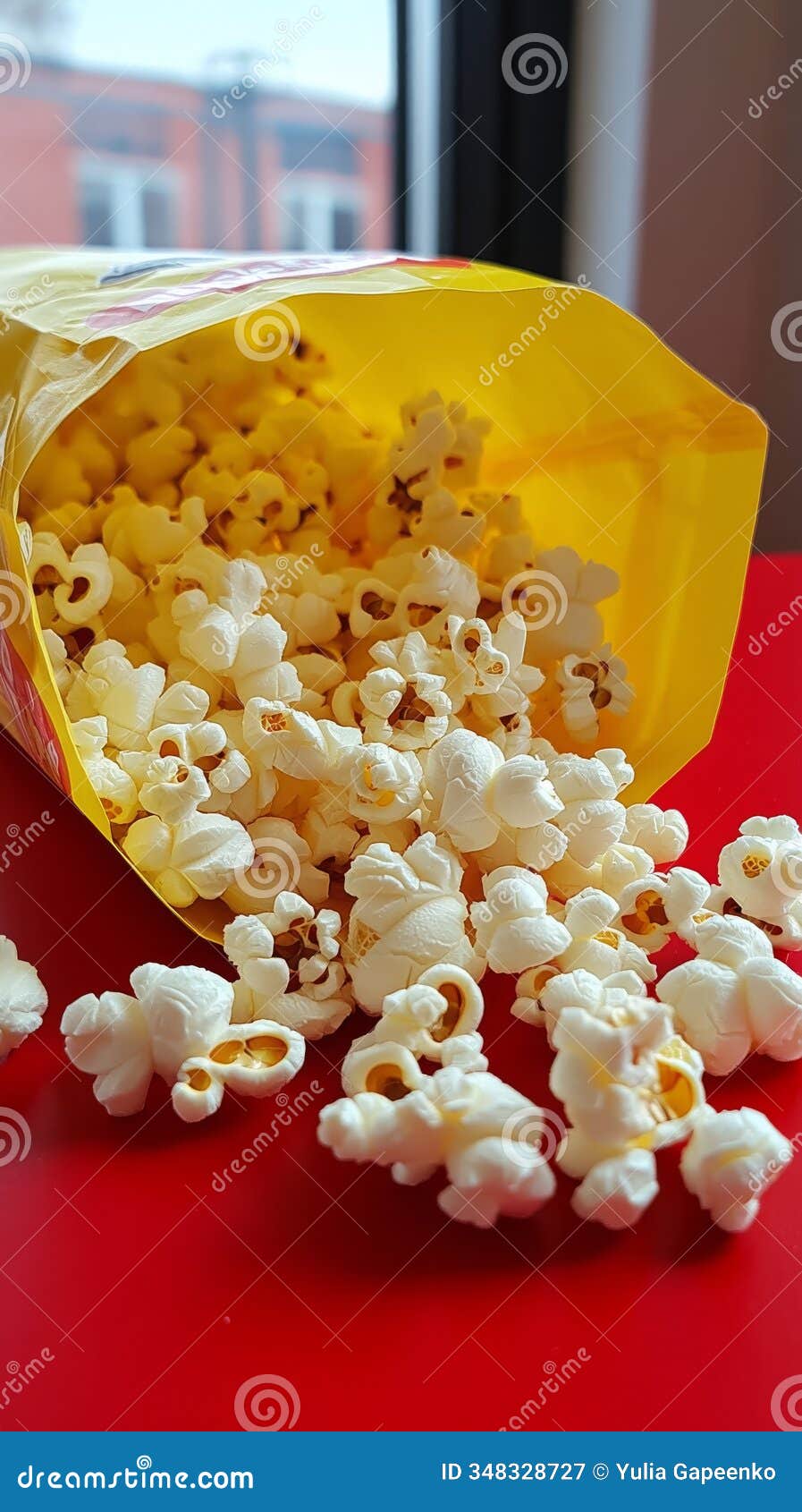 Spilled Popcorn Spilling from a Container on a Red Surface at a Casual ...