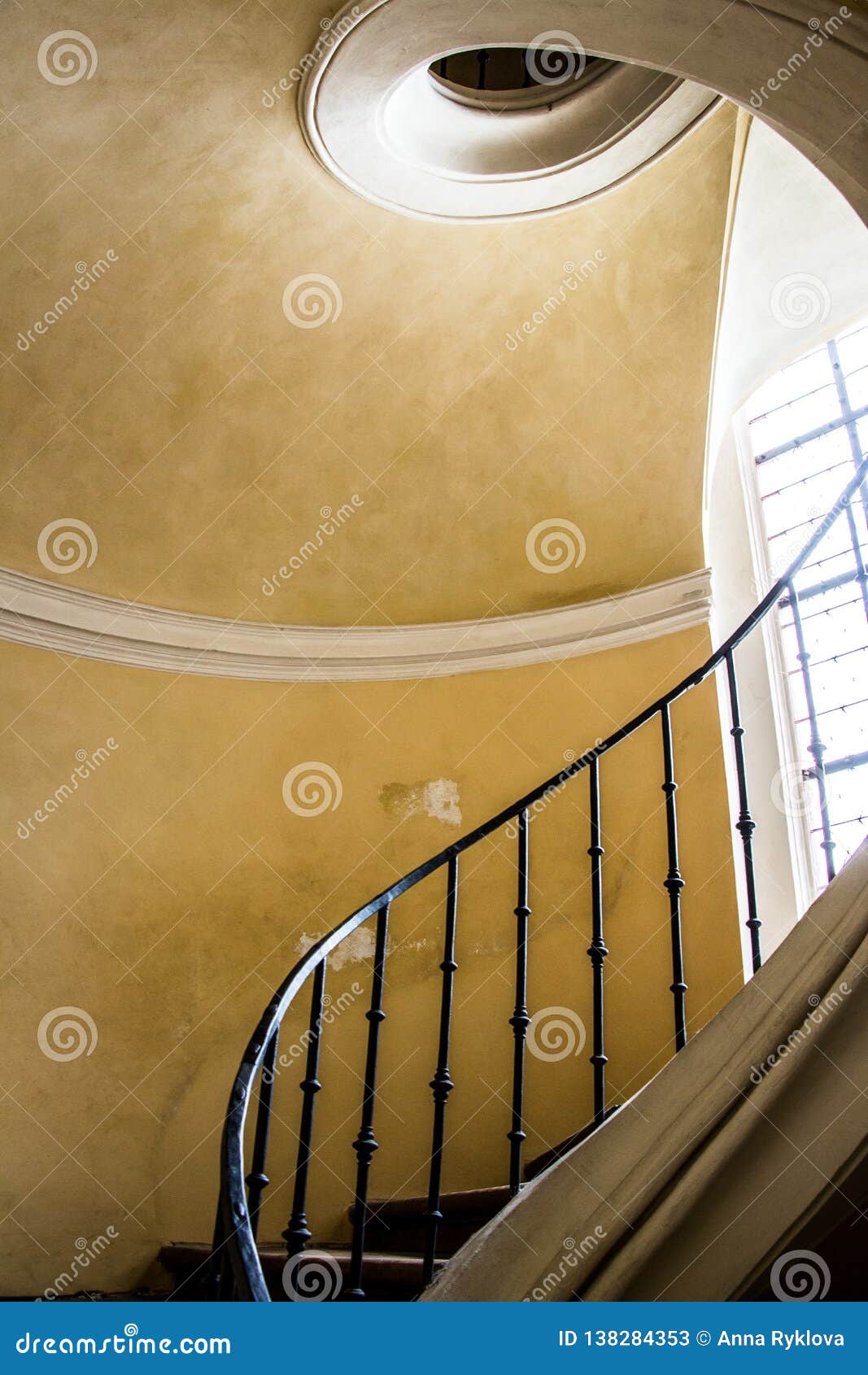 Spiral Staircase with Dark Railing and Yellow Wall Stock Image - Image ...