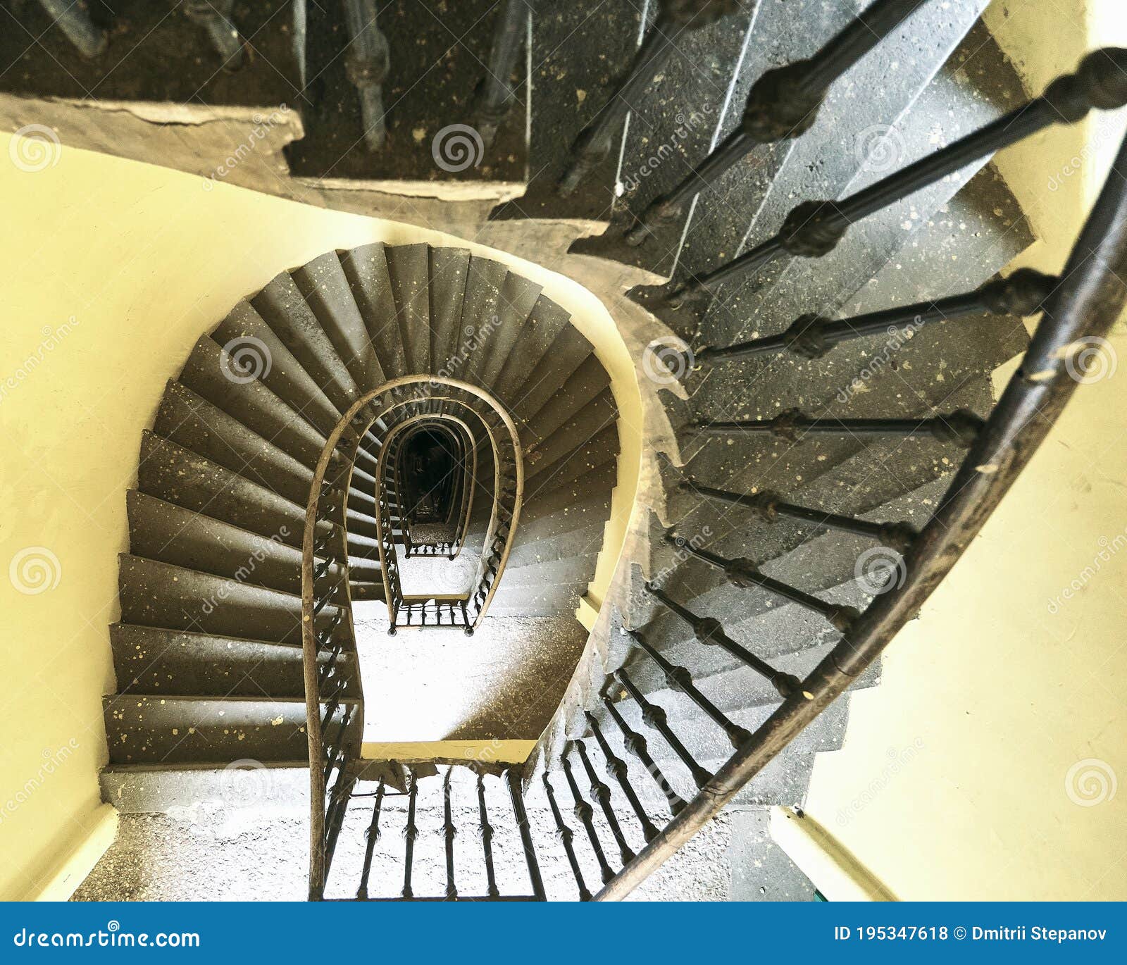 Spiral Staircase with Yellow Walls and Black Railings Down View Stock ...