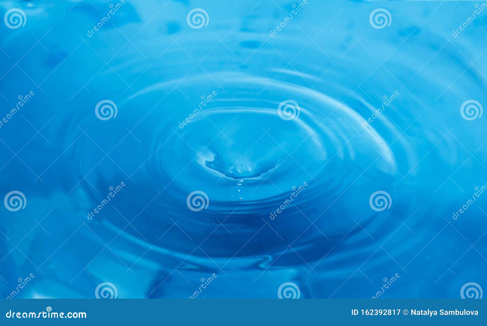 A Splash of Blue Water. a Drop of Water on a Blue Background. Splashing ...