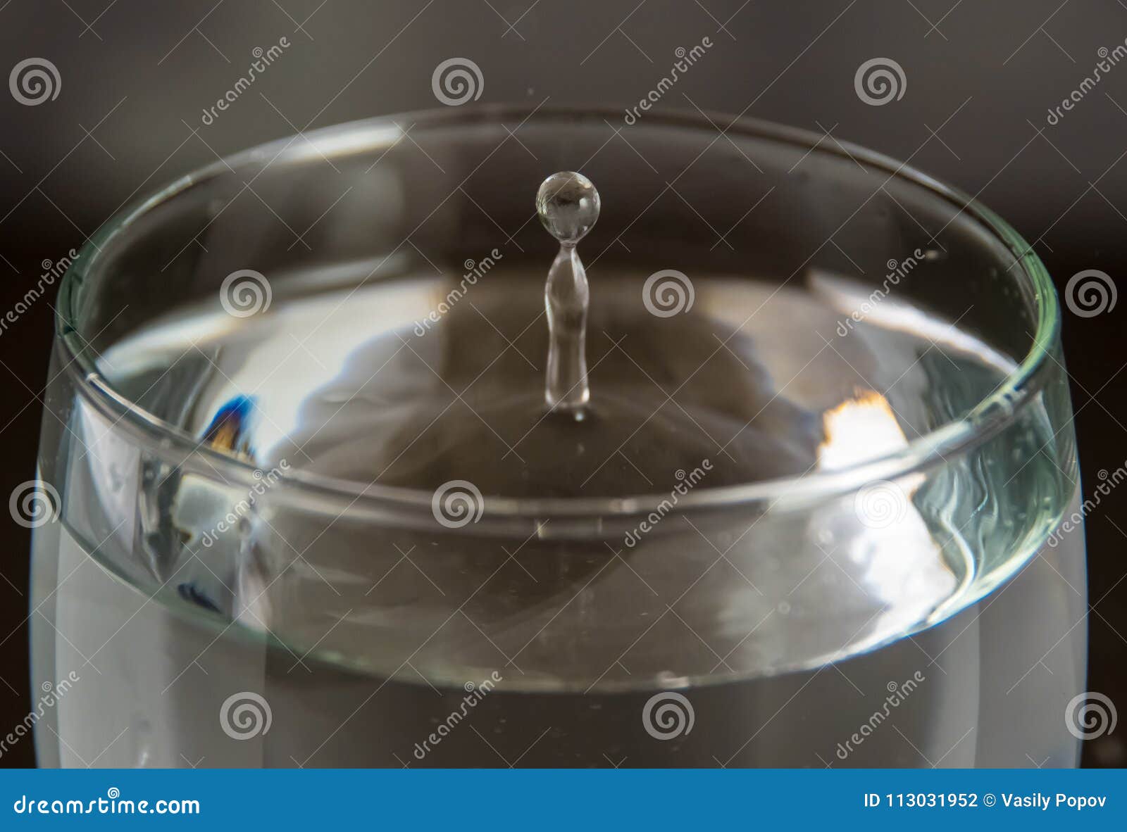 Splash from a Drop of Water Dropped into a Glass with Water Stock Photo ...