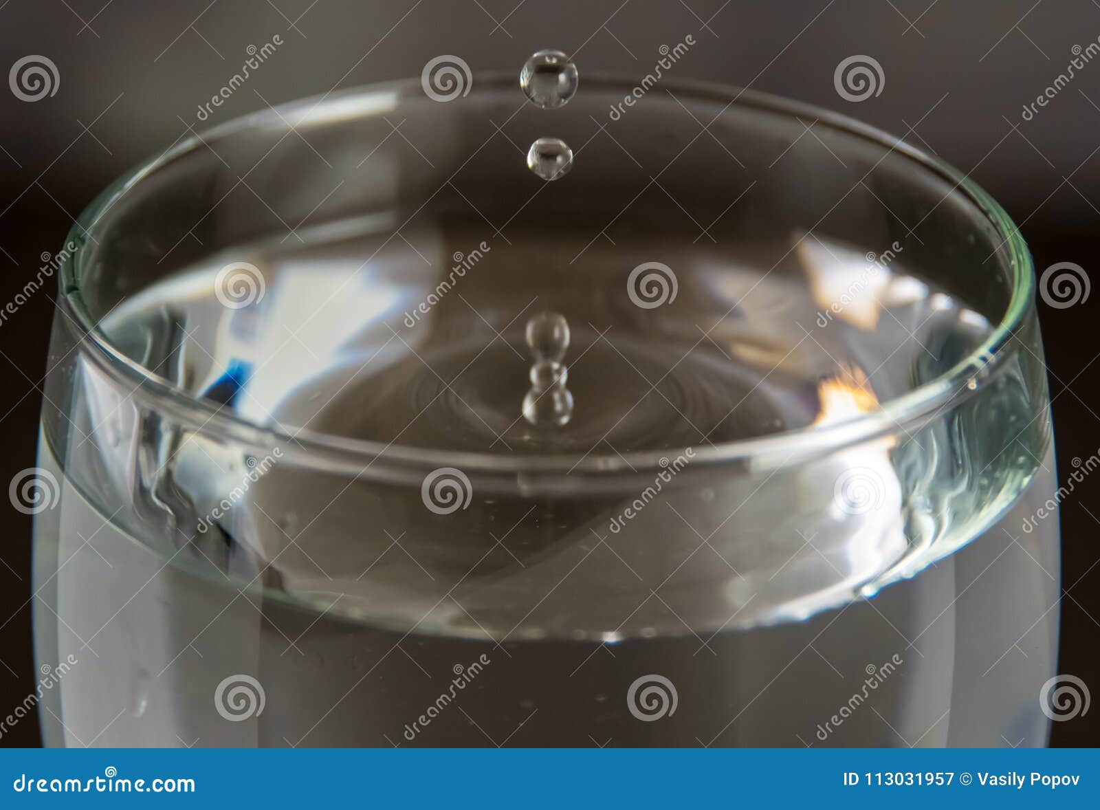 Splash from a Drop of Water Dropped into a Glass with Water Stock Image ...