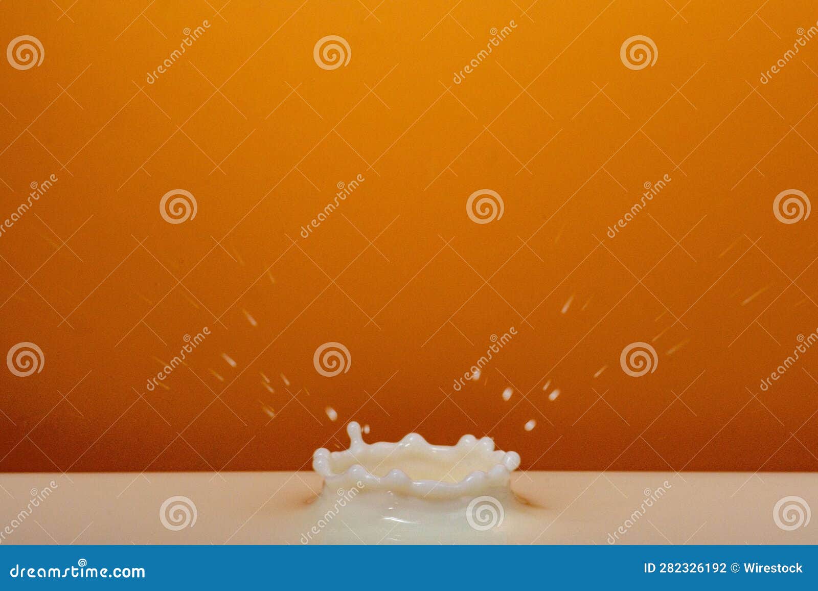 Splash of Milk Falling Off Against an Orange Background Stock Photo ...
