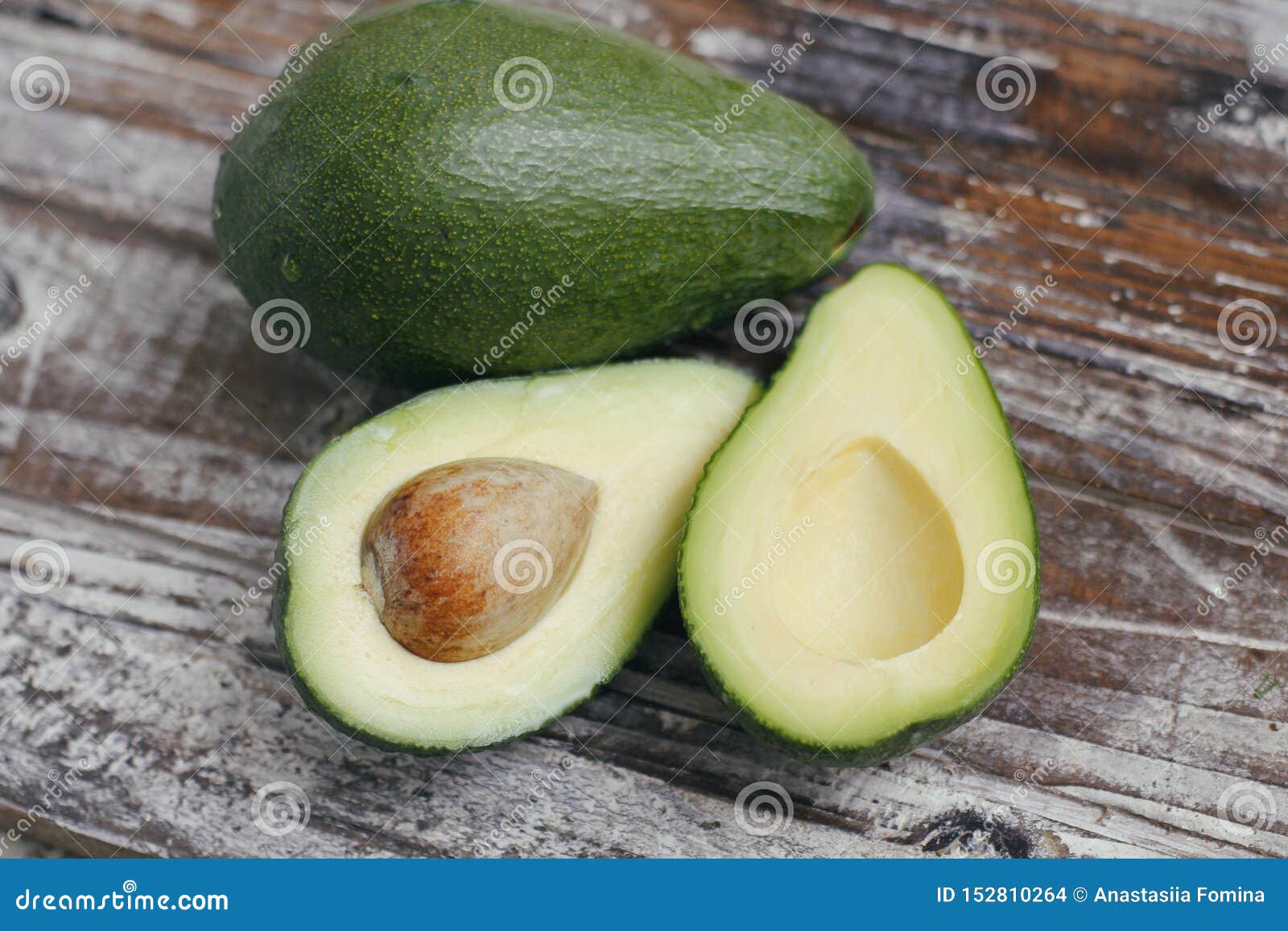 Split Fresh Raw Avocado with and without Pit. on Wooden Table. Stock ...