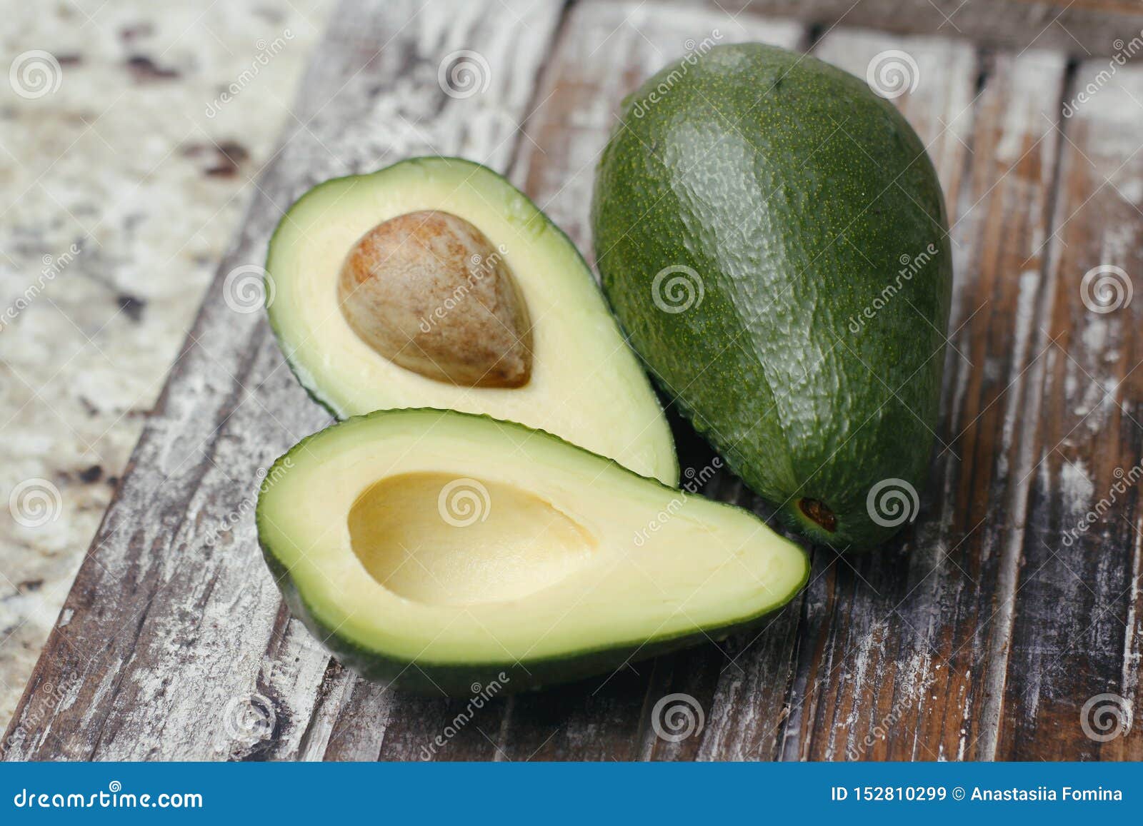 Split Fresh Raw Avocado with and without Pit. on Wooden Table. Stock ...