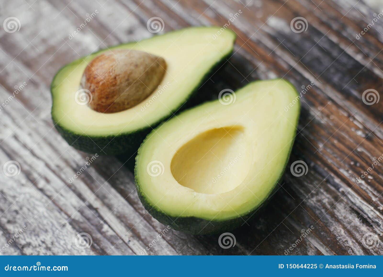 Split Fresh Raw Avocado with and without Pit. on Wooden Table. Stock ...