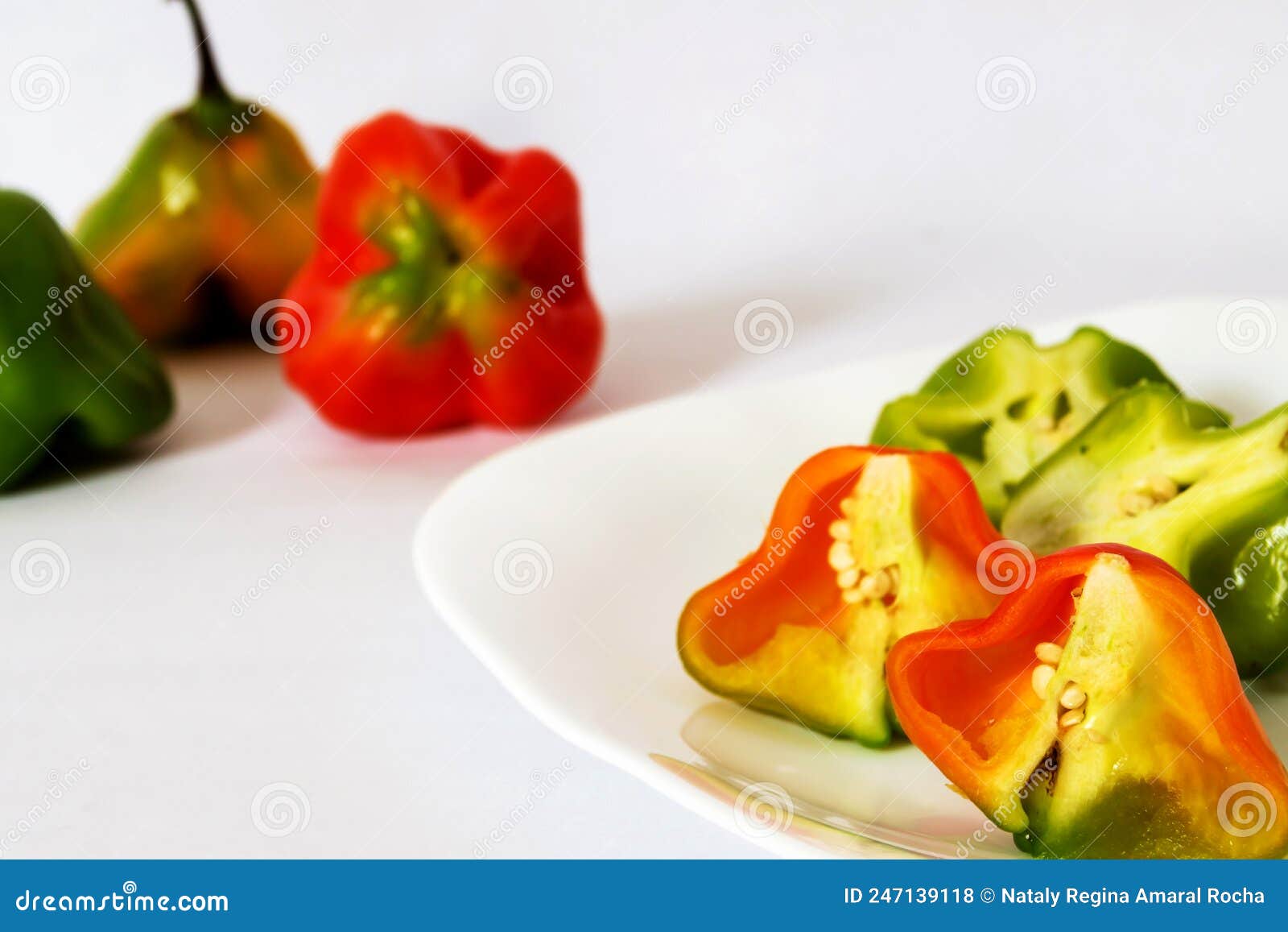 Split Pepper on the Plate and Two Peppers on the Left Side Stock Photo ...
