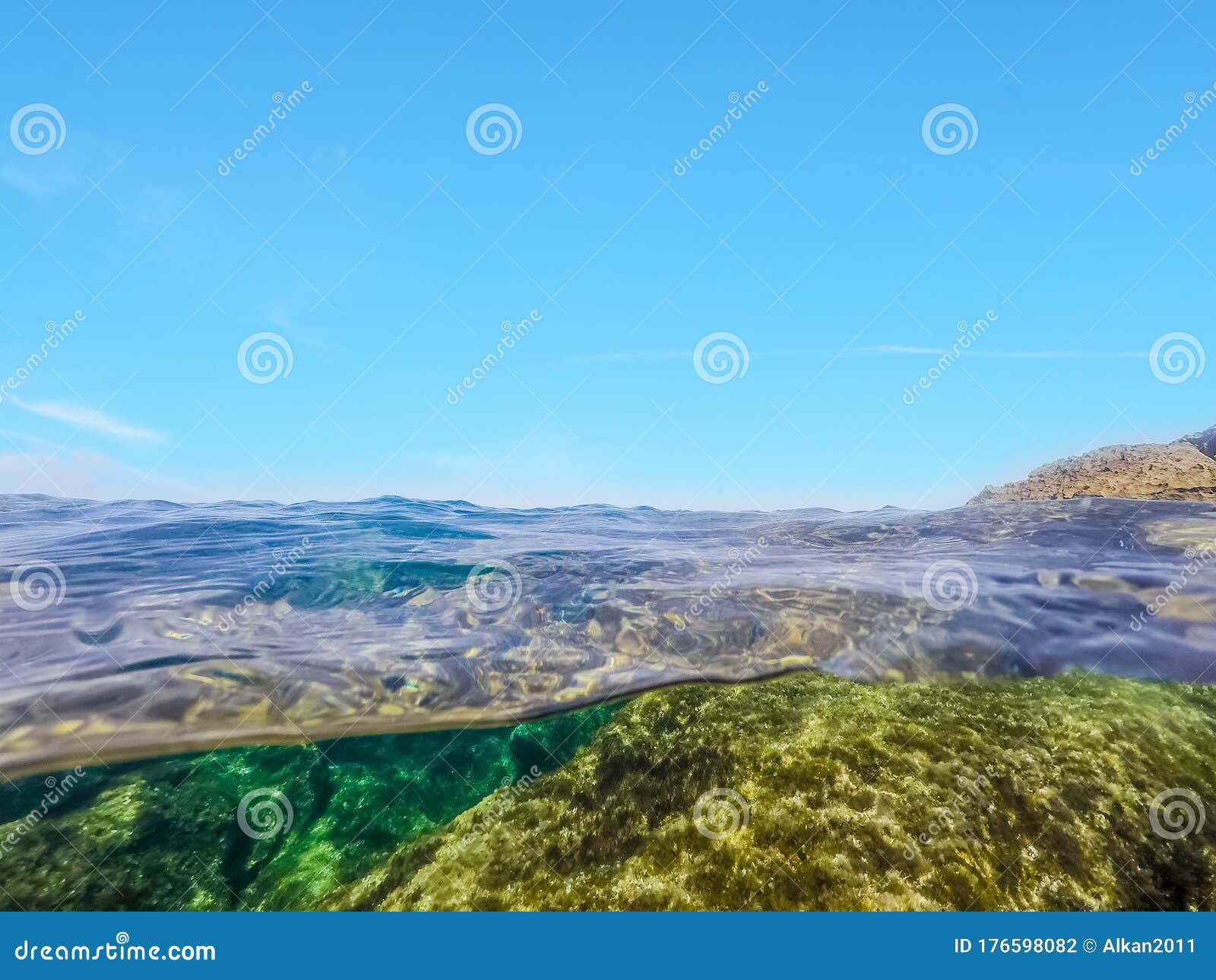 Split Underwater View of Rocks Under the Sea and Blue Sky in Alghero ...