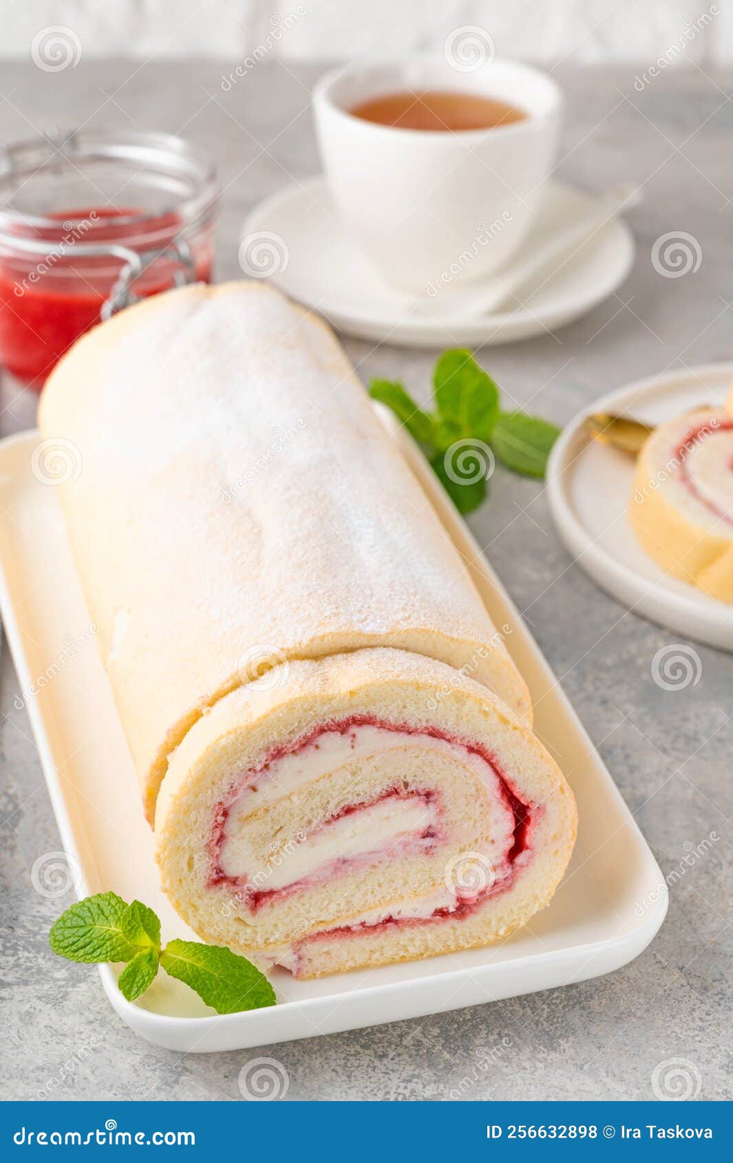 Sponge Cake Roll with Strawberry Jam and Cream on a White Plate on a ...