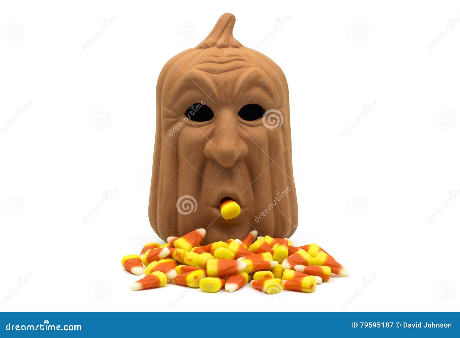 Spooky Faced Pumpkin Surrounded by Candy Corn with One in Its Mouth ...