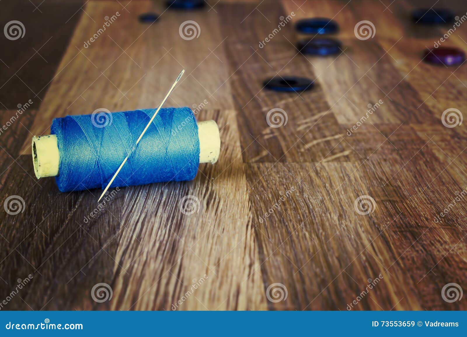 Spool of Blue Sewing Thread with a Needle and Buttons on Wooden ...