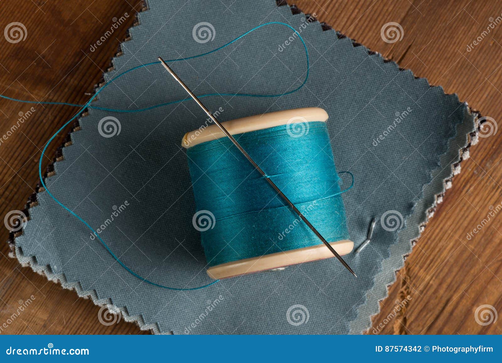 Spool of Blue Thread and Needle on Fabric Swatches Stock Photo - Image ...
