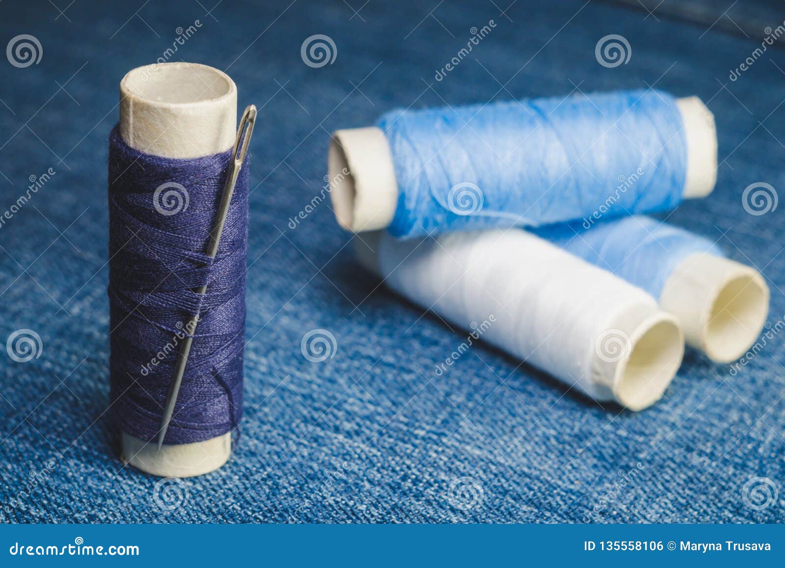 A Spool of Blue Threads with a Sewing Needle on the Background of ...
