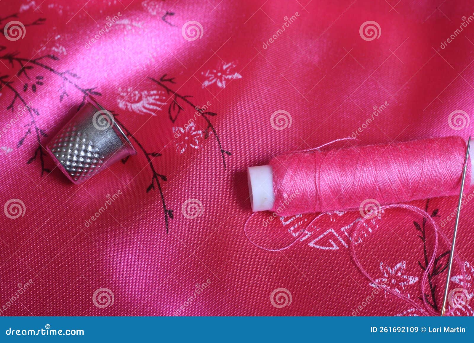 Spool of Pink Thread and Thimble on Vintage Pink Satin Fabric Stock ...