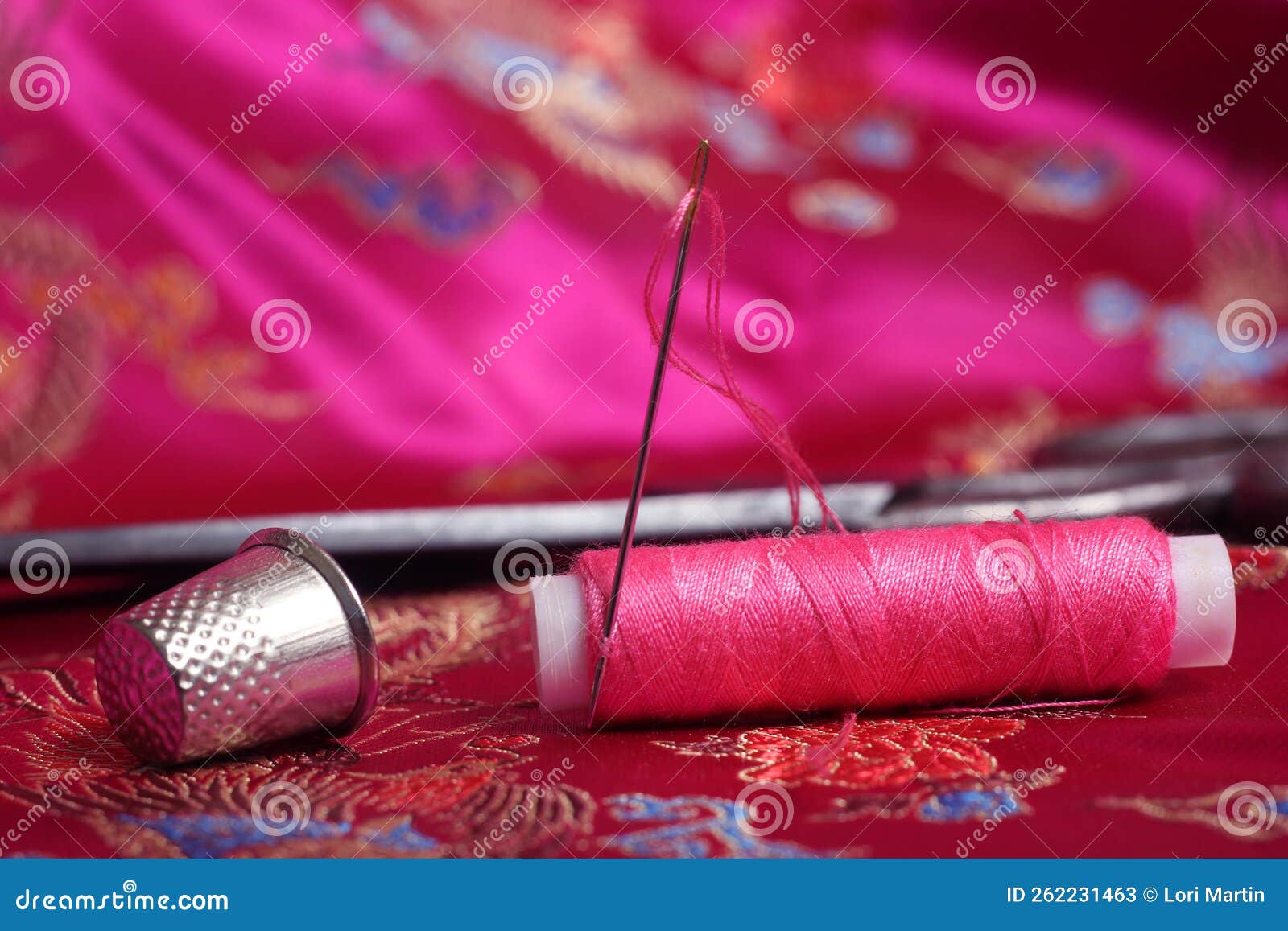 Spool of Pink Thread and Thimble on Vintage Pink Satin Fabric Stock ...