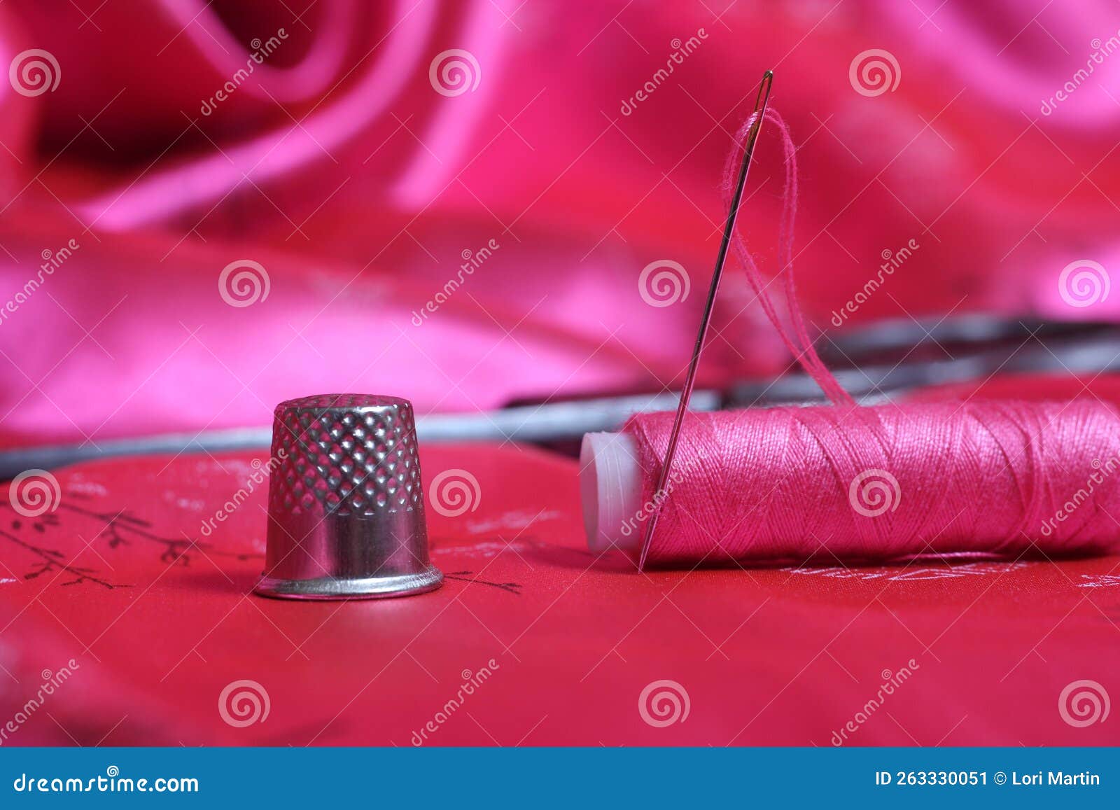 Spool of Pink Thread and Thimble on Vintage Pink Satin Fabric Stock ...