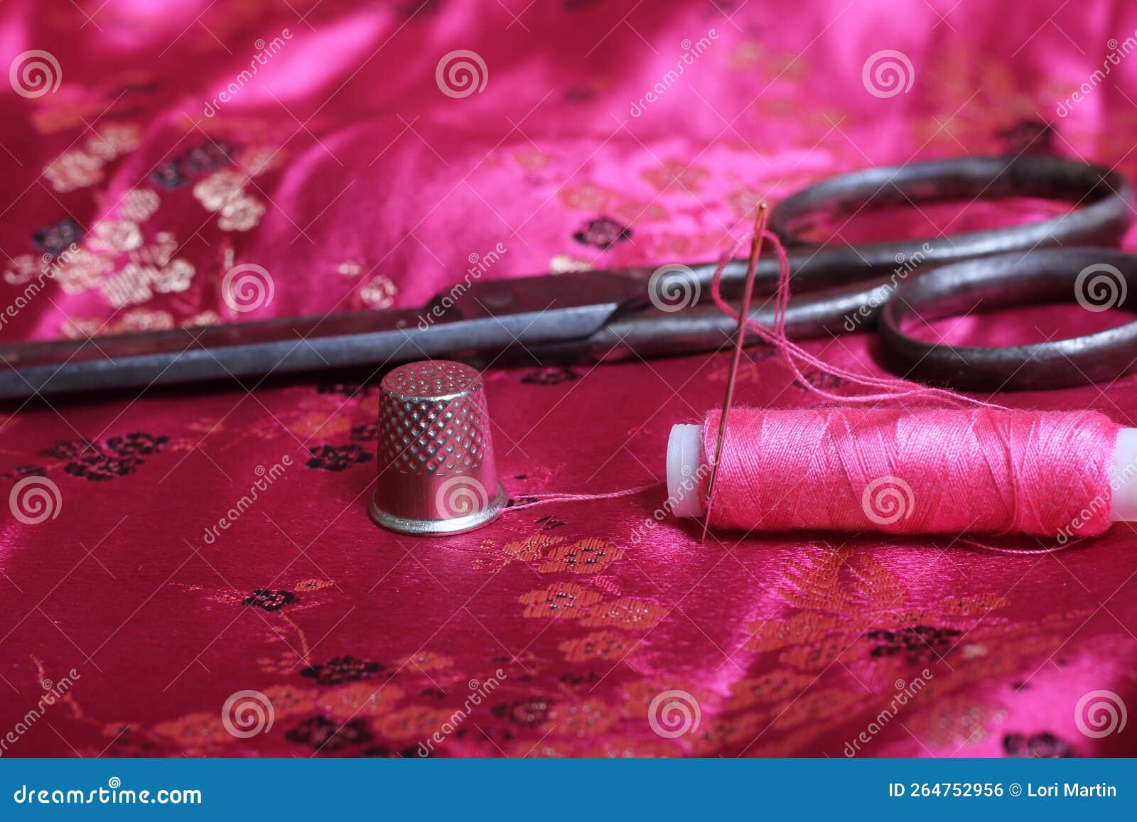 Spool of Pink Thread and Thimble on Vintage Pink Satin Fabric Stock ...
