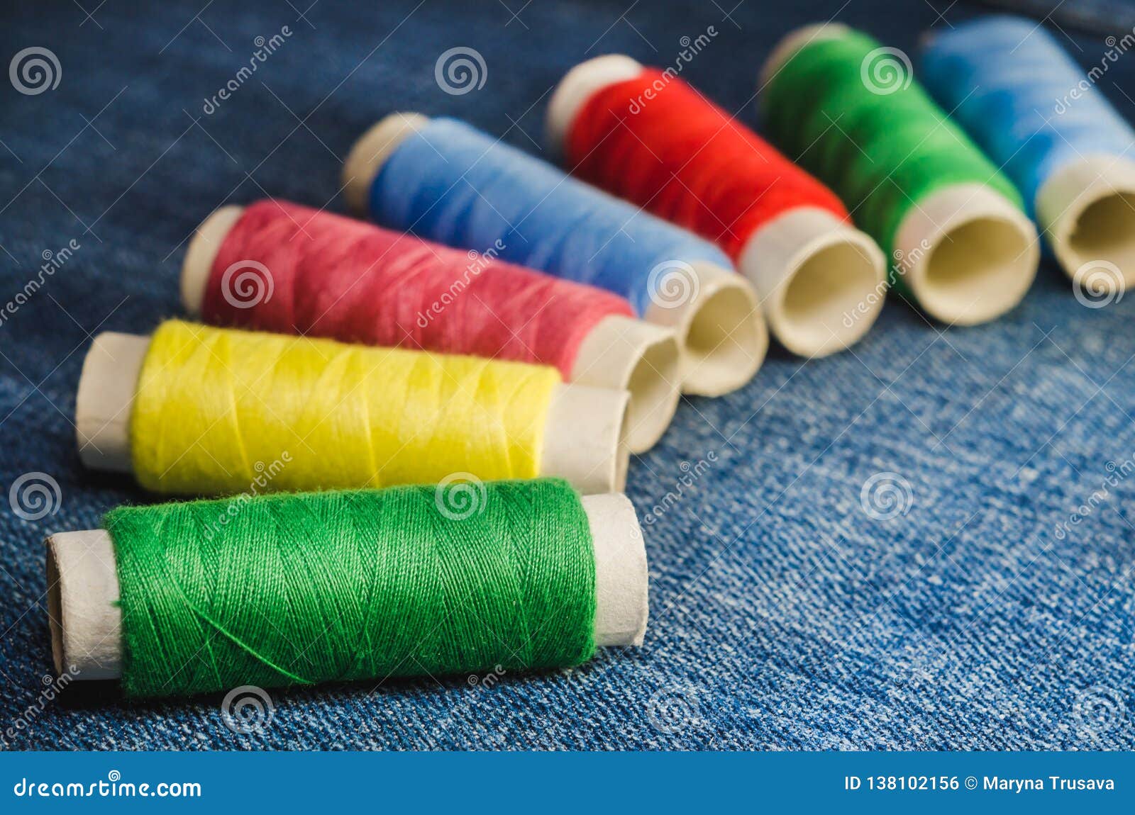 Spools of Colored Threads, Arranged in a Semicircle on a Denim Fabric ...