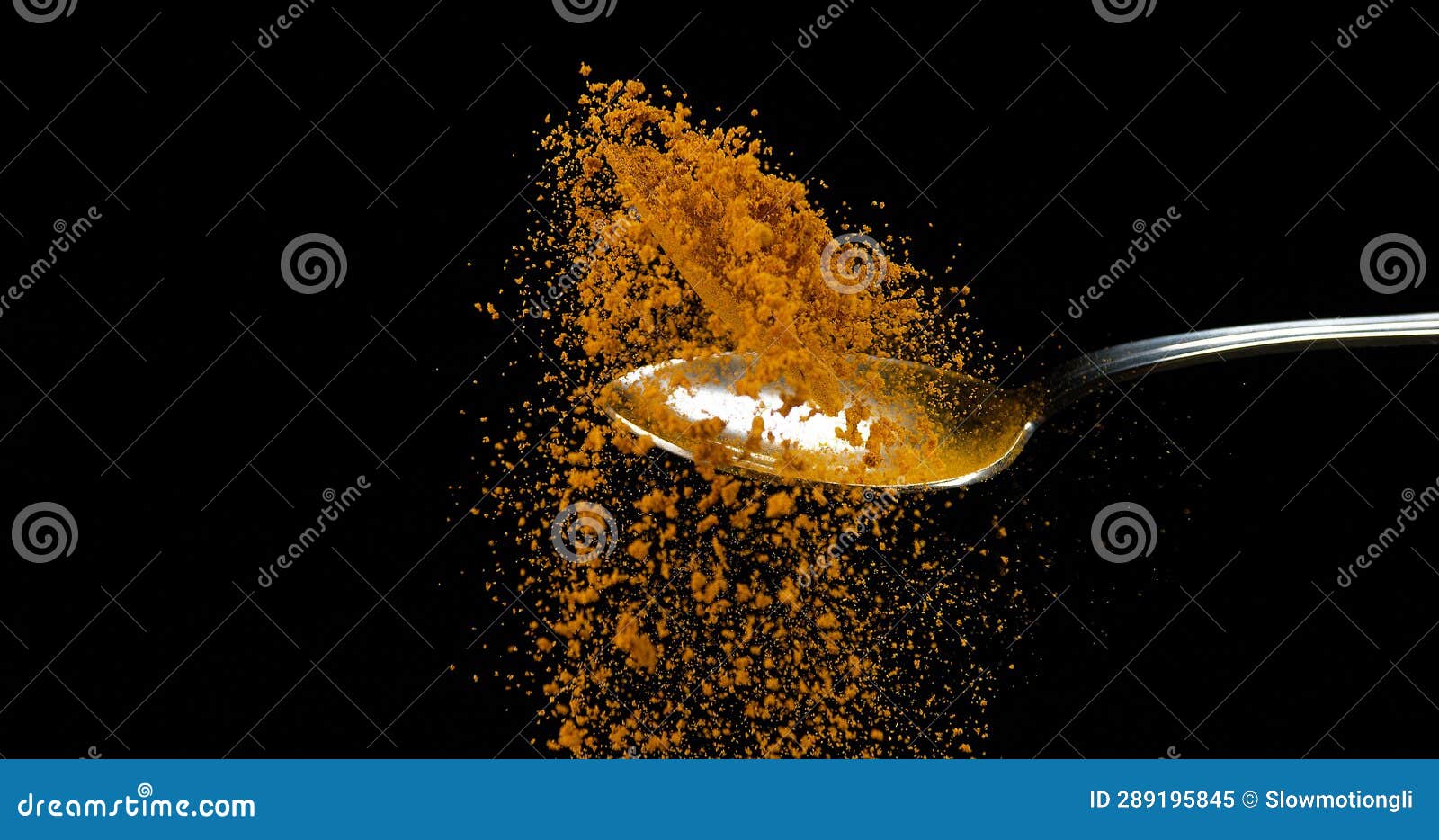 Spoon and Curry Powder Falling from Spoon Against Black Background ...