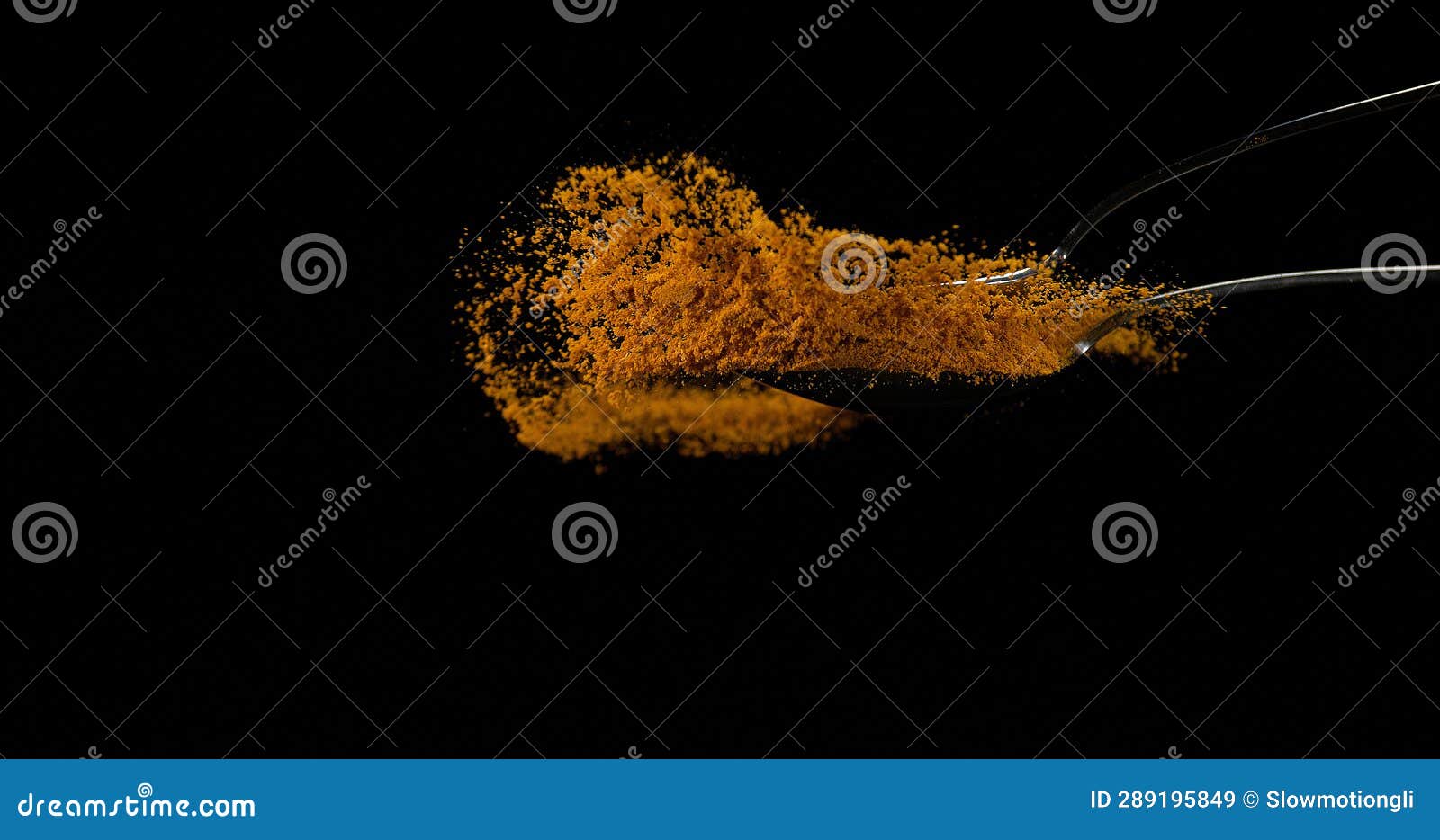 Spoon and Curry Powder Falling from Spoon Against Black Background ...