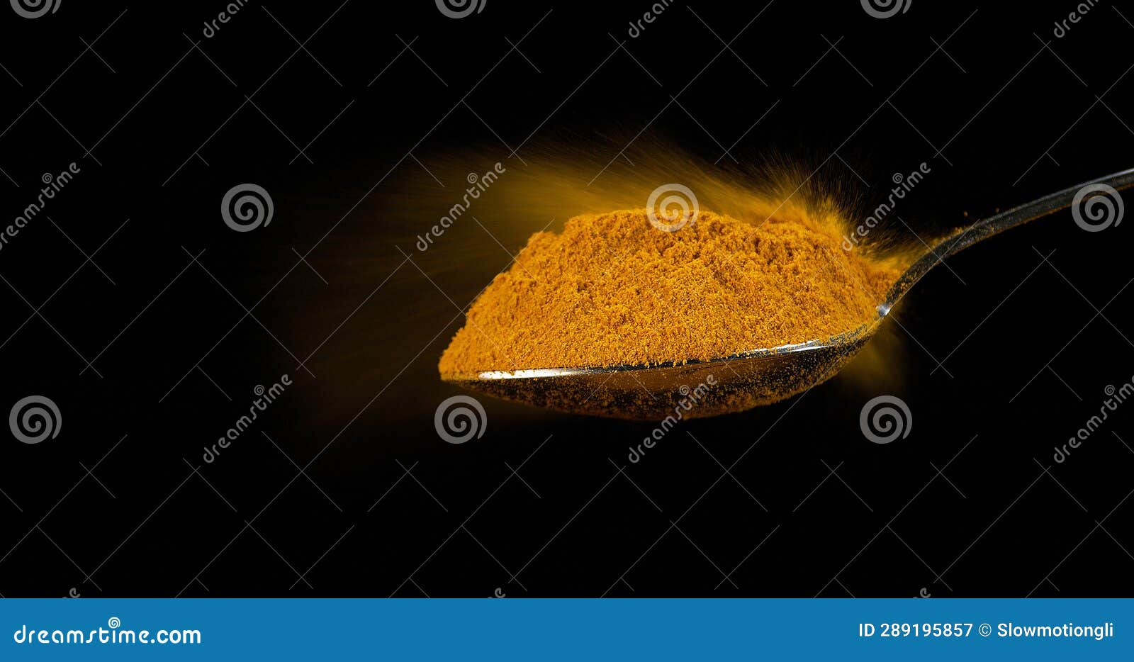 Spoon and Curry Powder Falling from Spoon Against Black Background ...
