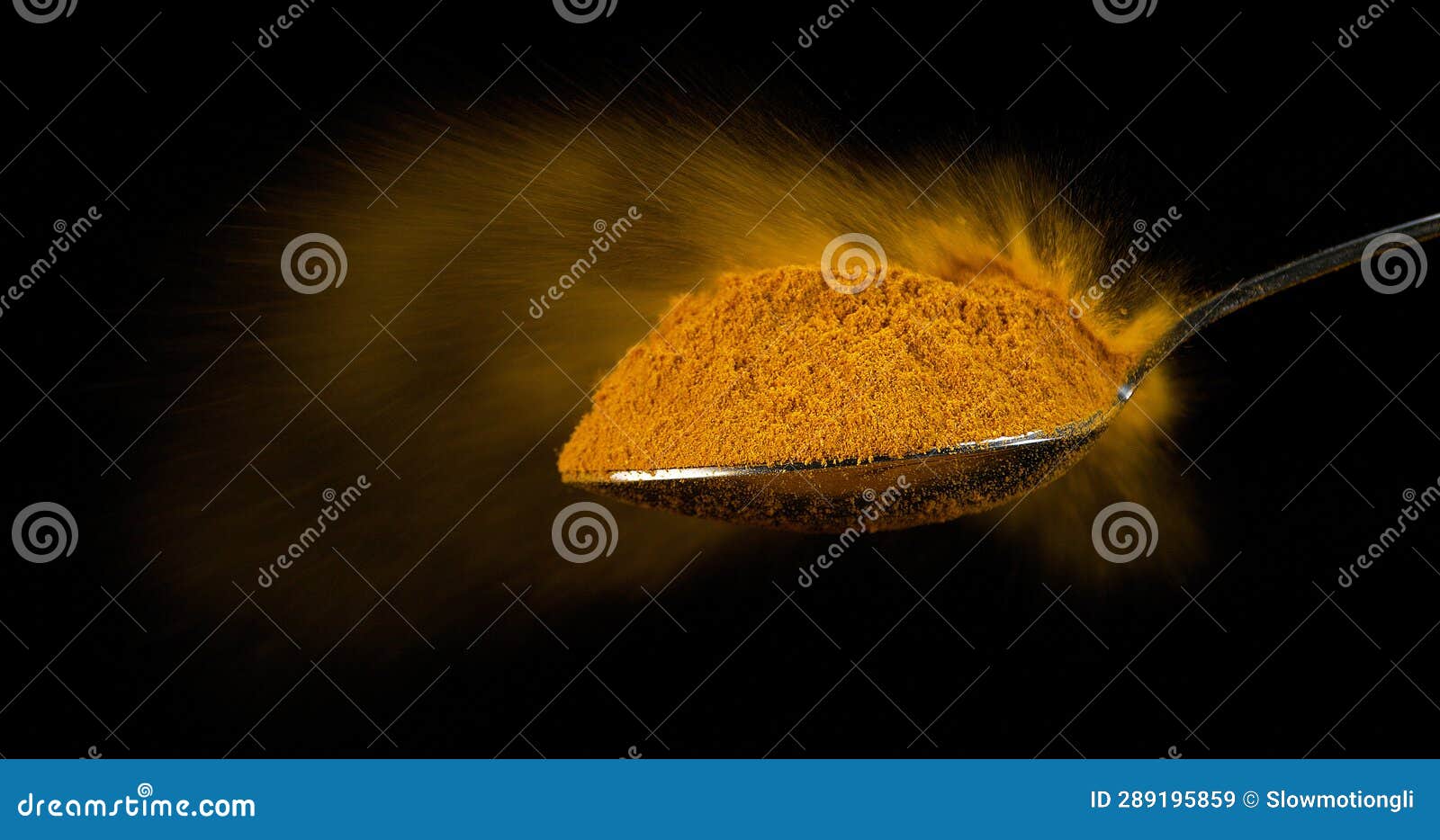 Spoon and Curry Powder Falling from Spoon Against Black Background ...