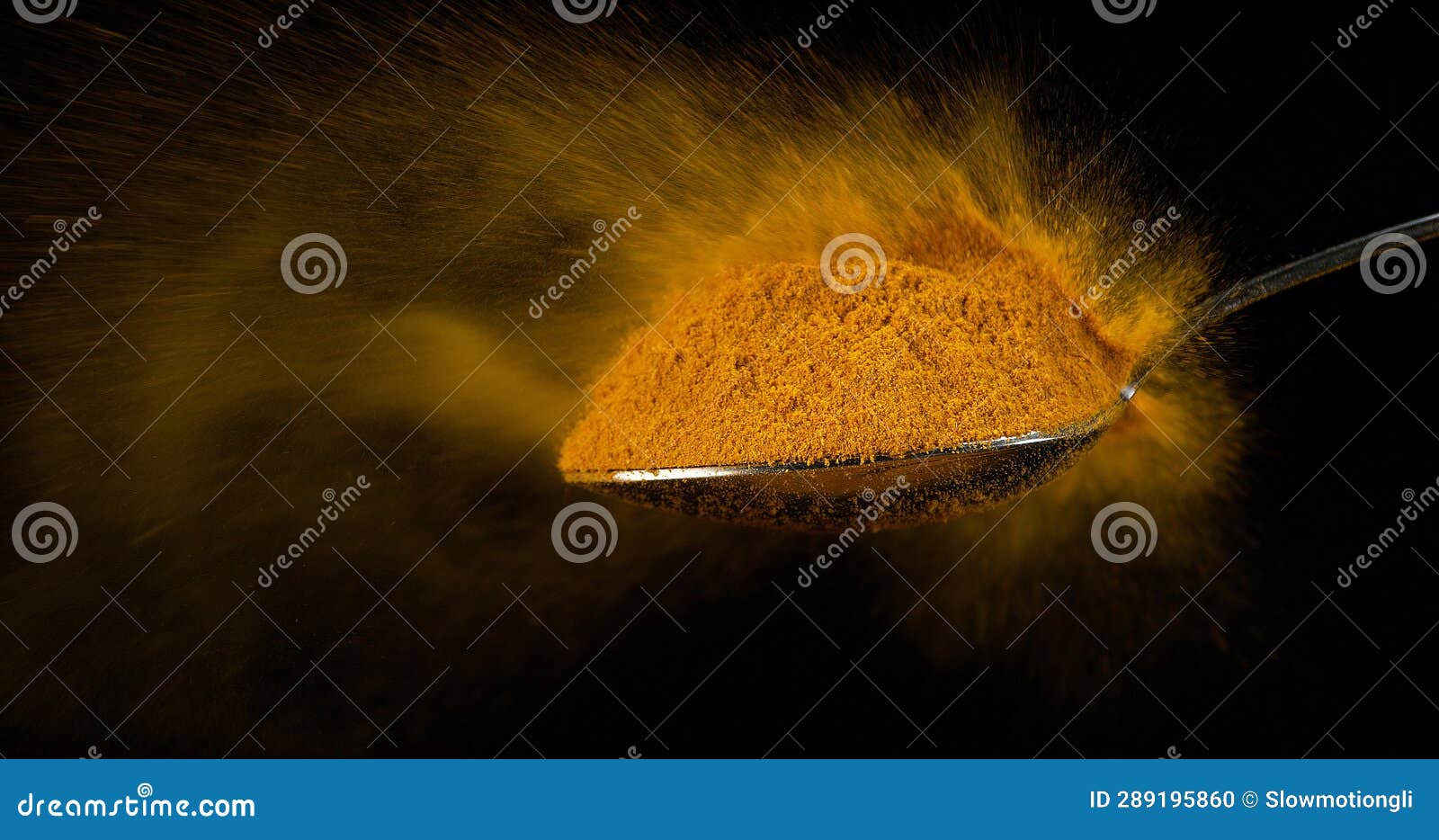 Spoon and Curry Powder Falling from Spoon Against Black Background ...