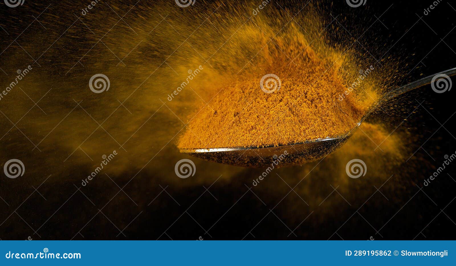Spoon and Curry Powder Falling from Spoon Against Black Background ...
