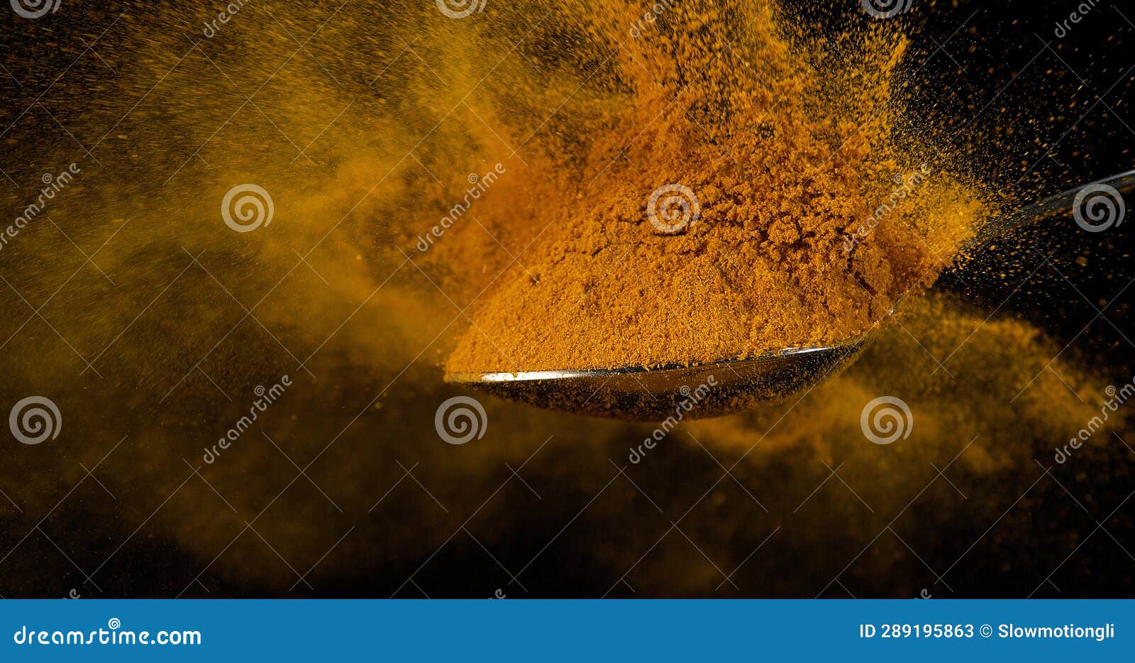 Spoon and Curry Powder Falling from Spoon Against Black Background ...