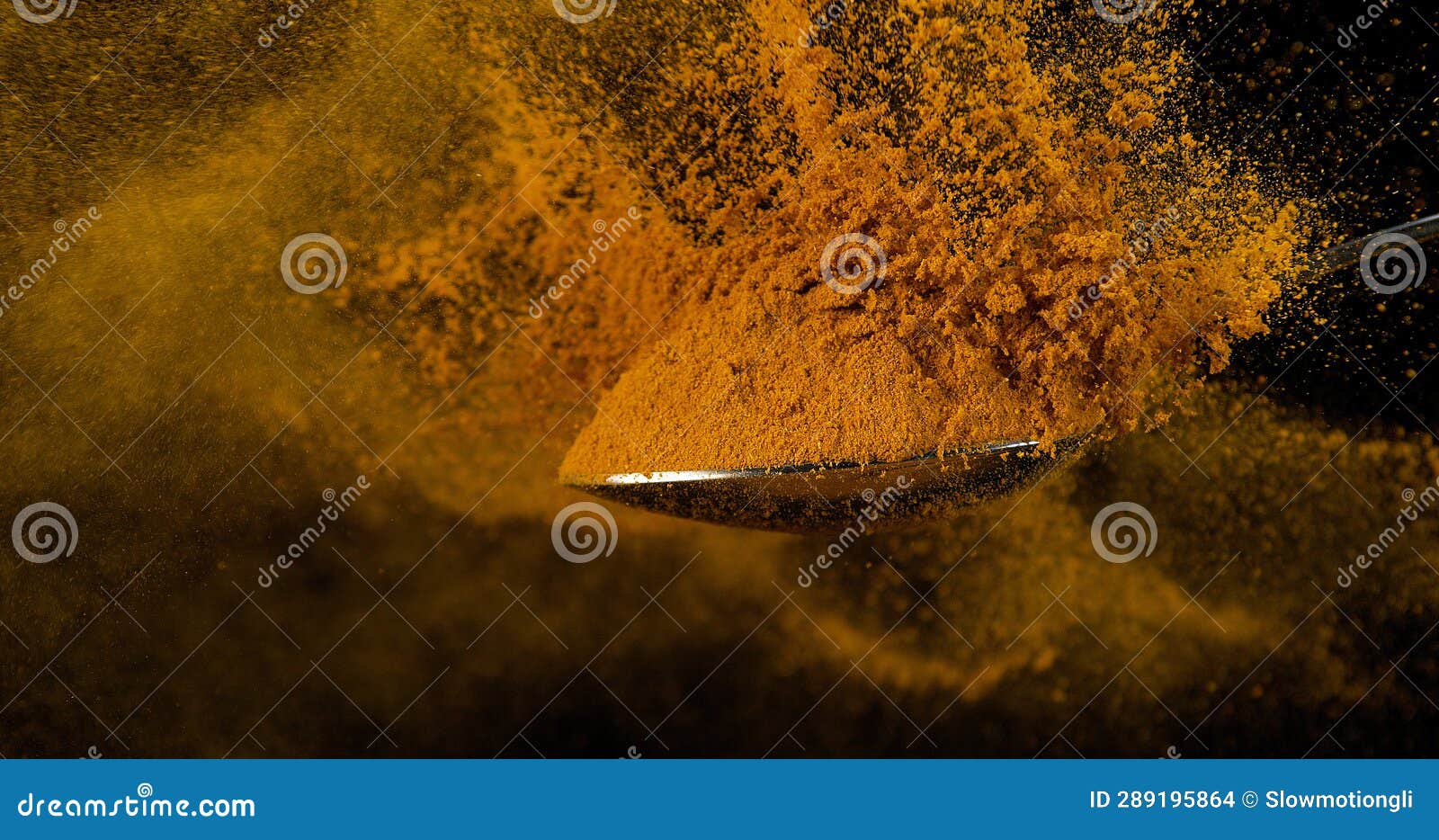 Spoon and Curry Powder Falling from Spoon Against Black Background ...
