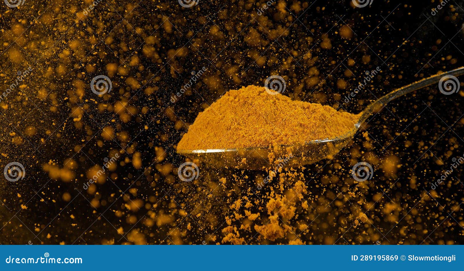 Spoon and Curry Powder Falling from Spoon Against Black Background ...