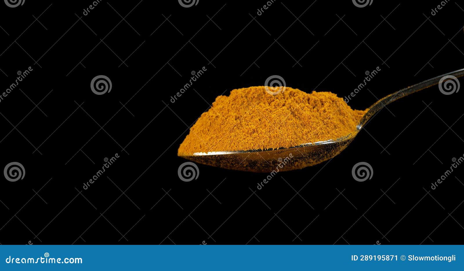 Spoon and Curry Powder Falling from Spoon Against Black Background ...