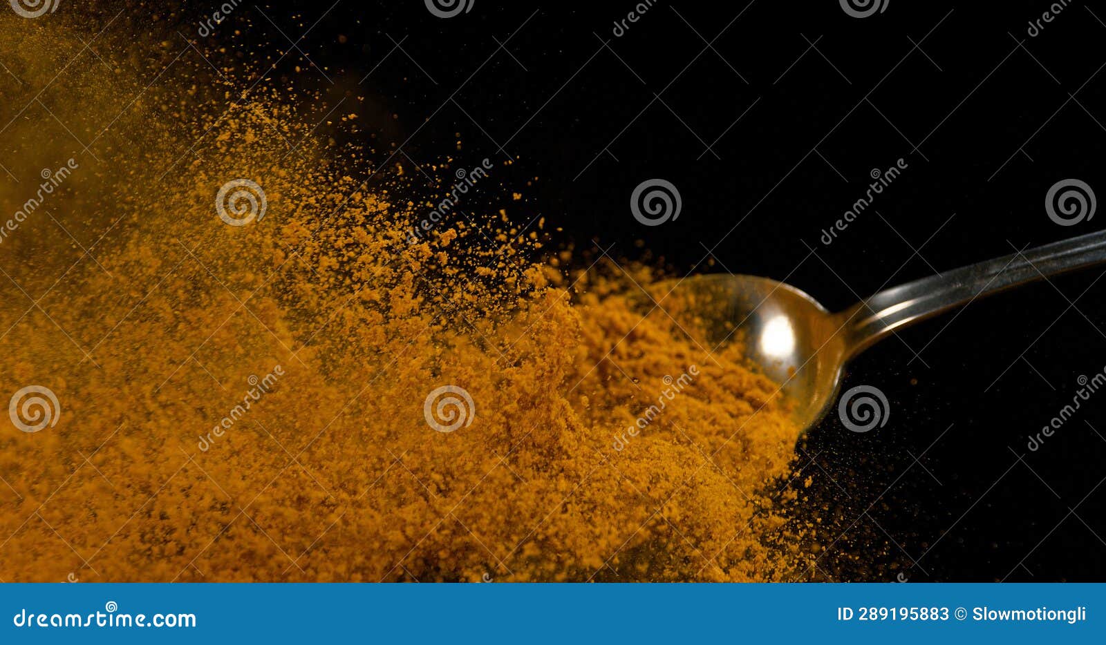 Spoon and Curry Powder Falling from Spoon Against Black Background ...