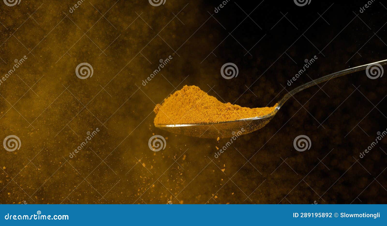 Spoon and Curry Powder Falling from Spoon Against Black Background ...