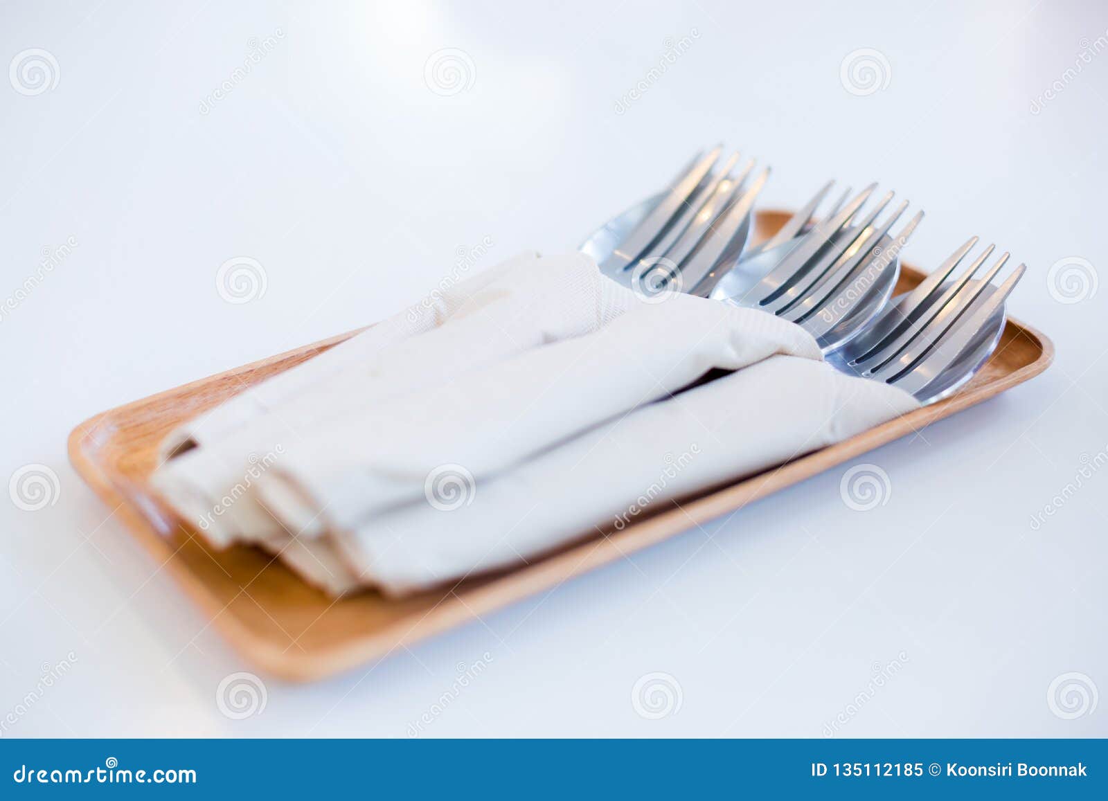 Spoon and Fork Wrapped in Tissue Paper on a Wooden Tray Stock Image ...