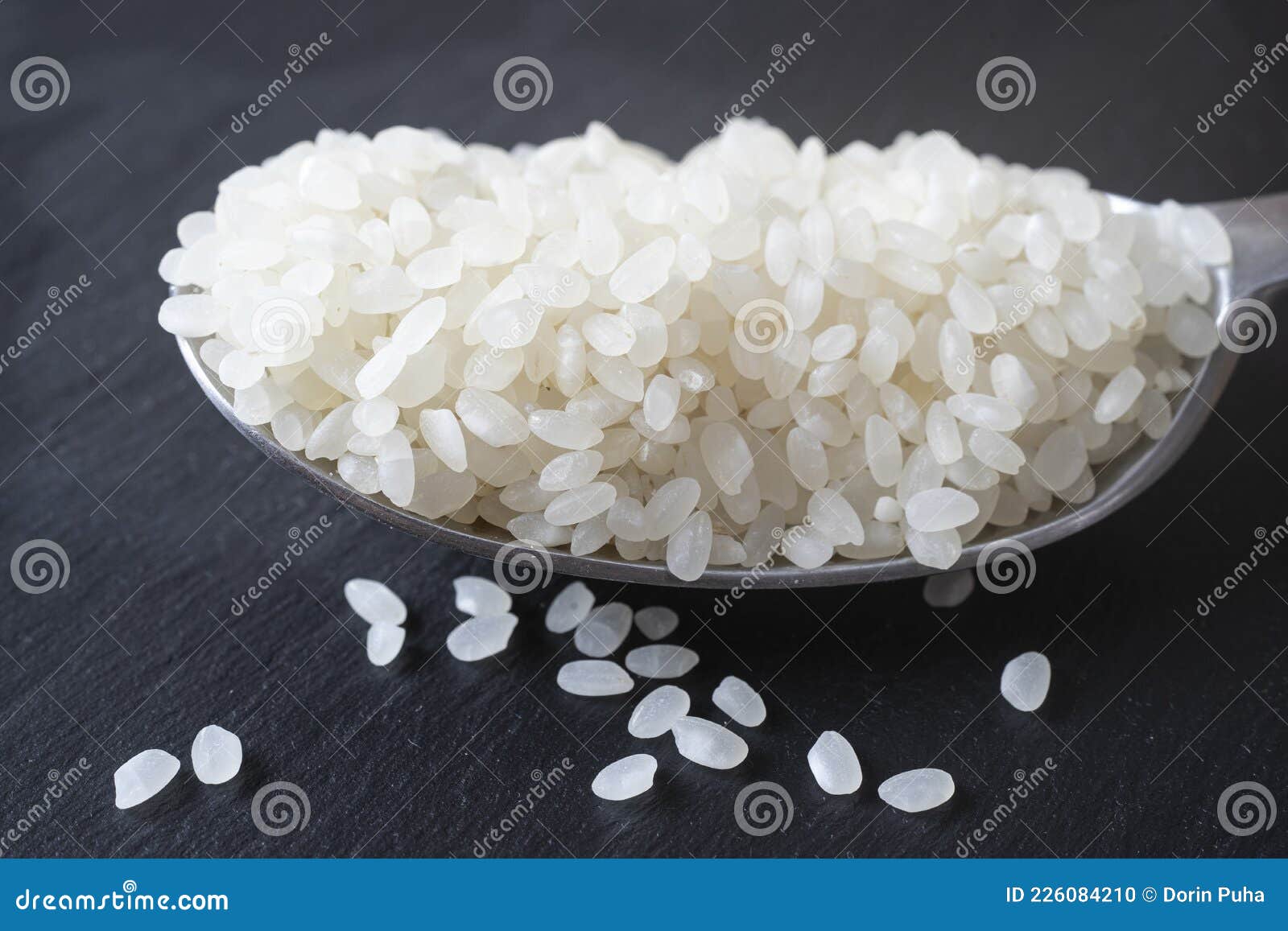 Spoon Full of White Rice Isolated on a Black Stone Tile Stock Photo ...