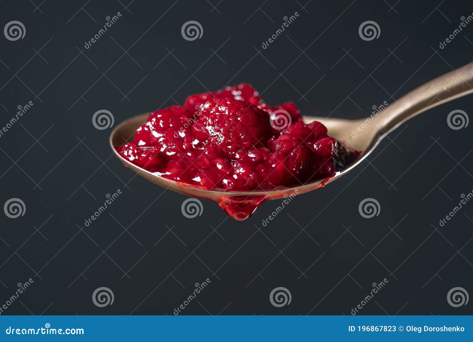 Thick Red Raspberry Jam Dripping from the Spoon, One Drop, on Black ...