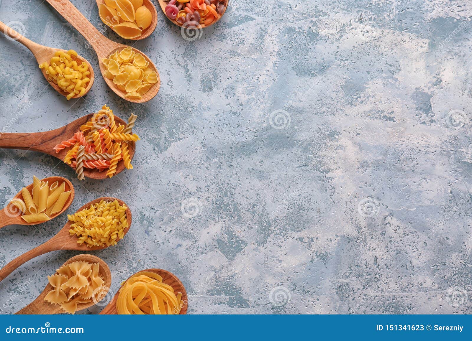 Spoons with Different Types of Raw Pasta on Color Table Stock Image ...