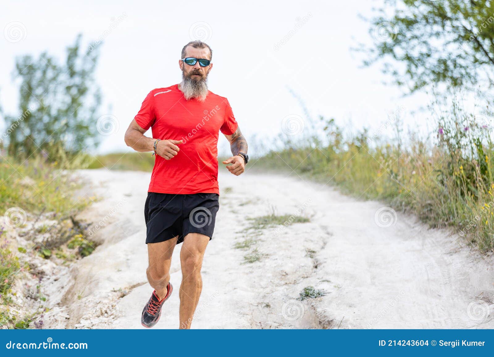 Sporty Bearded Man Running on the Path at Hillside Stock Photo - Image ...