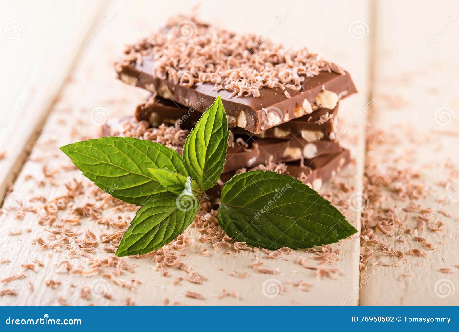 Sprig of Mint in Front of Chocolate Stack on White Board Stock Photo ...