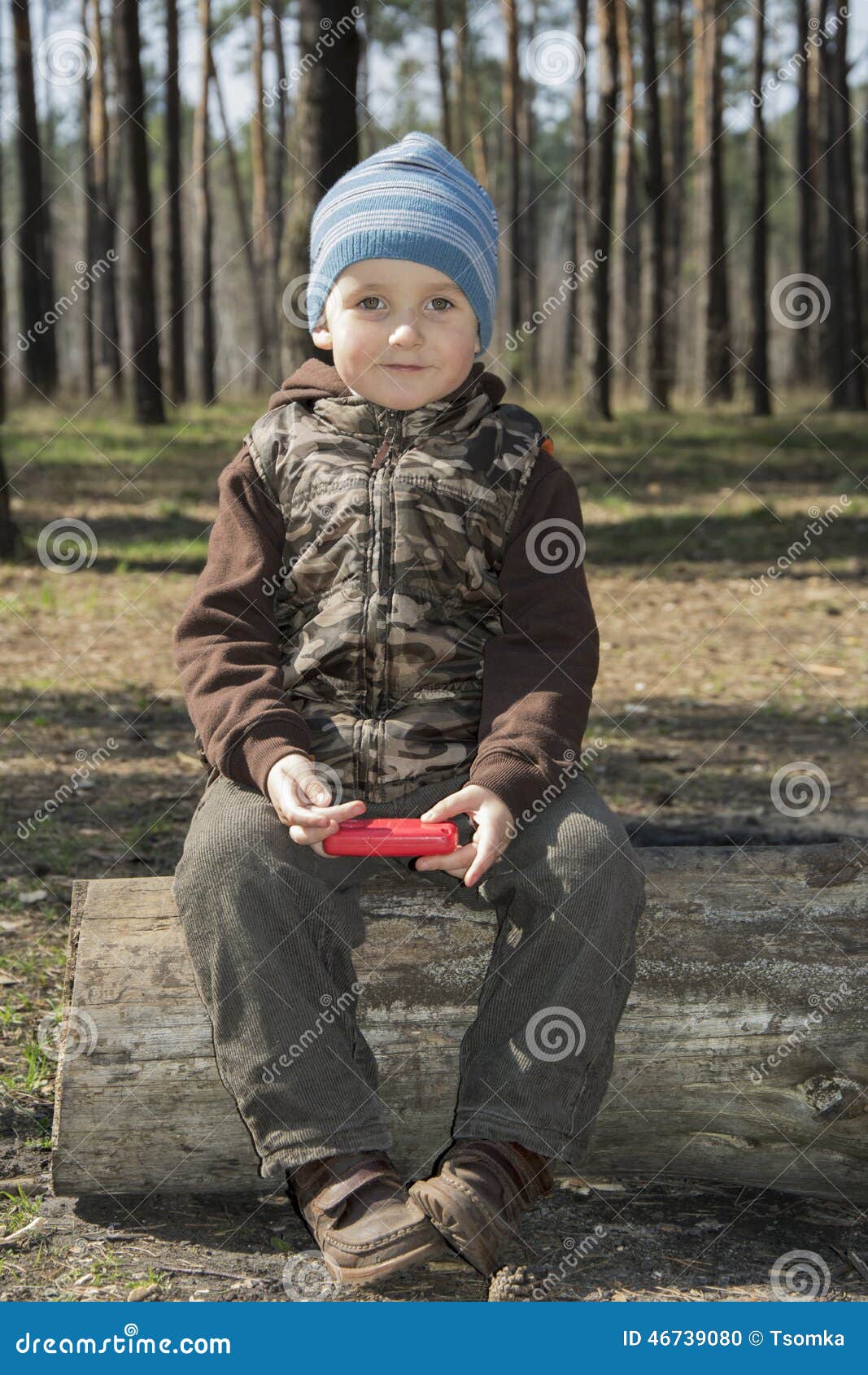 In the Spring of a Little Boy Sitting on a Log in the Forest. Stock ...